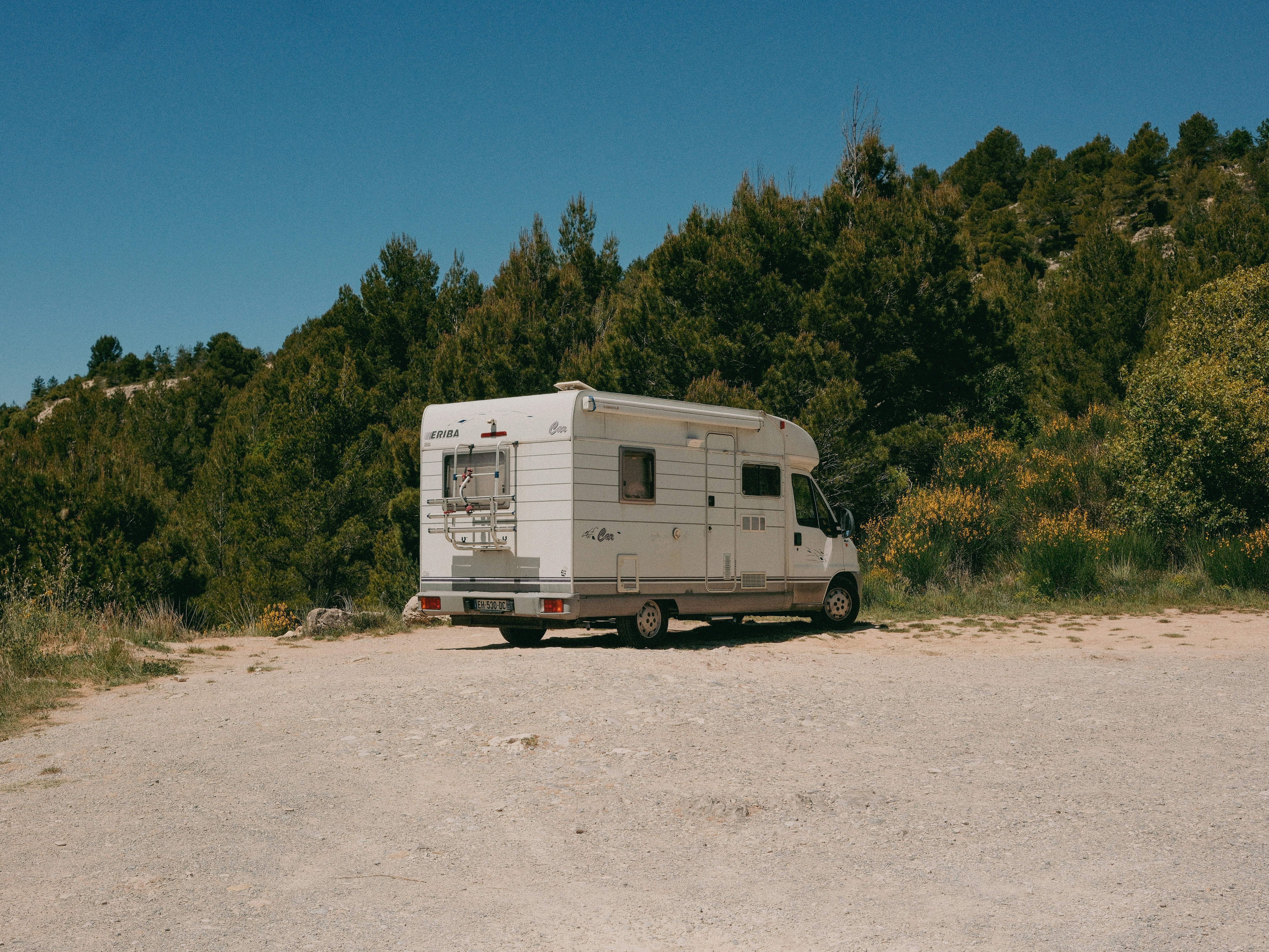 Quiet Rest Stop: A lone motorhome on a sunlit gravel spread