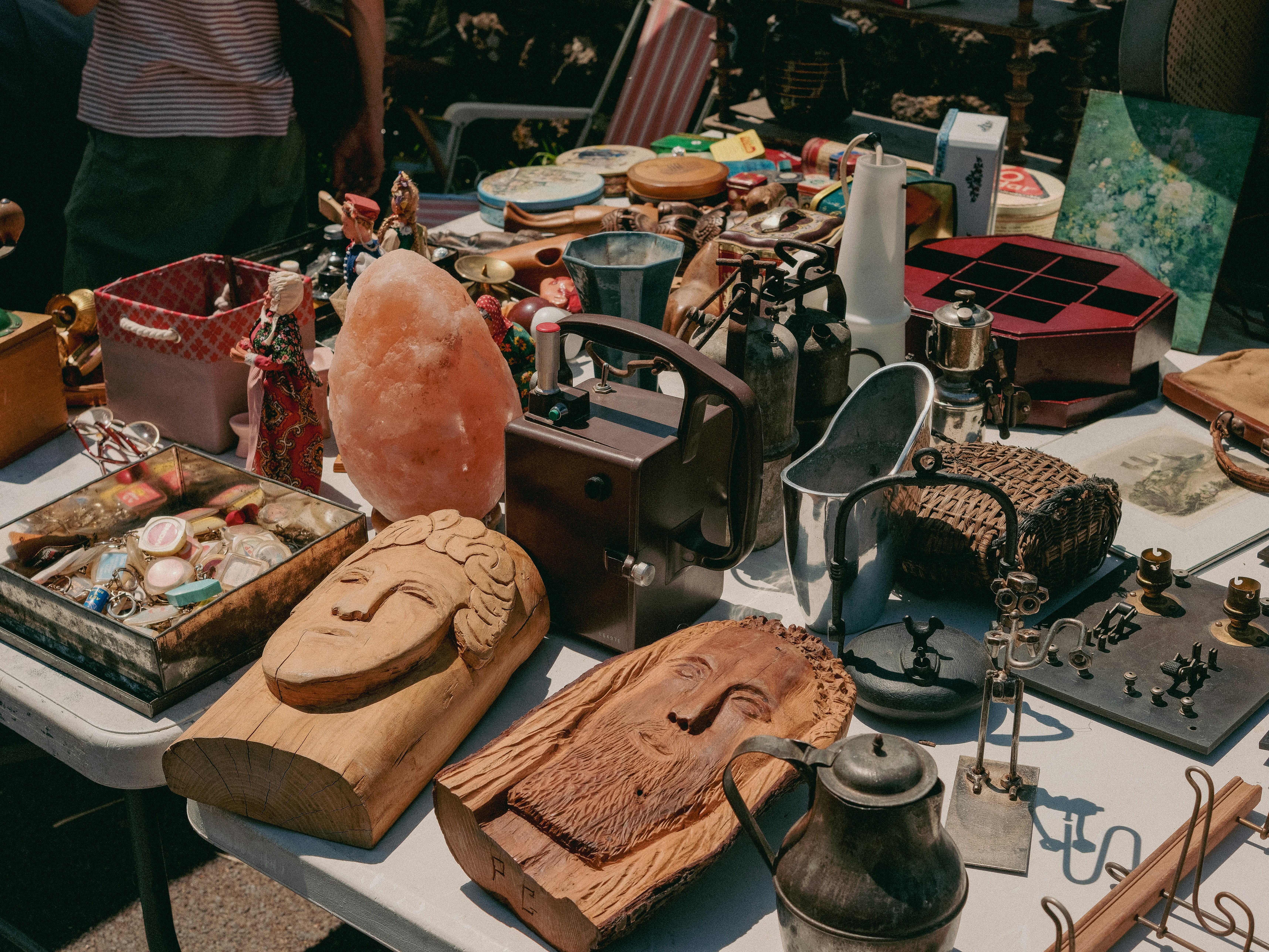 Wooden Masks and Salted Trinkets on a Sunlit Market Table
