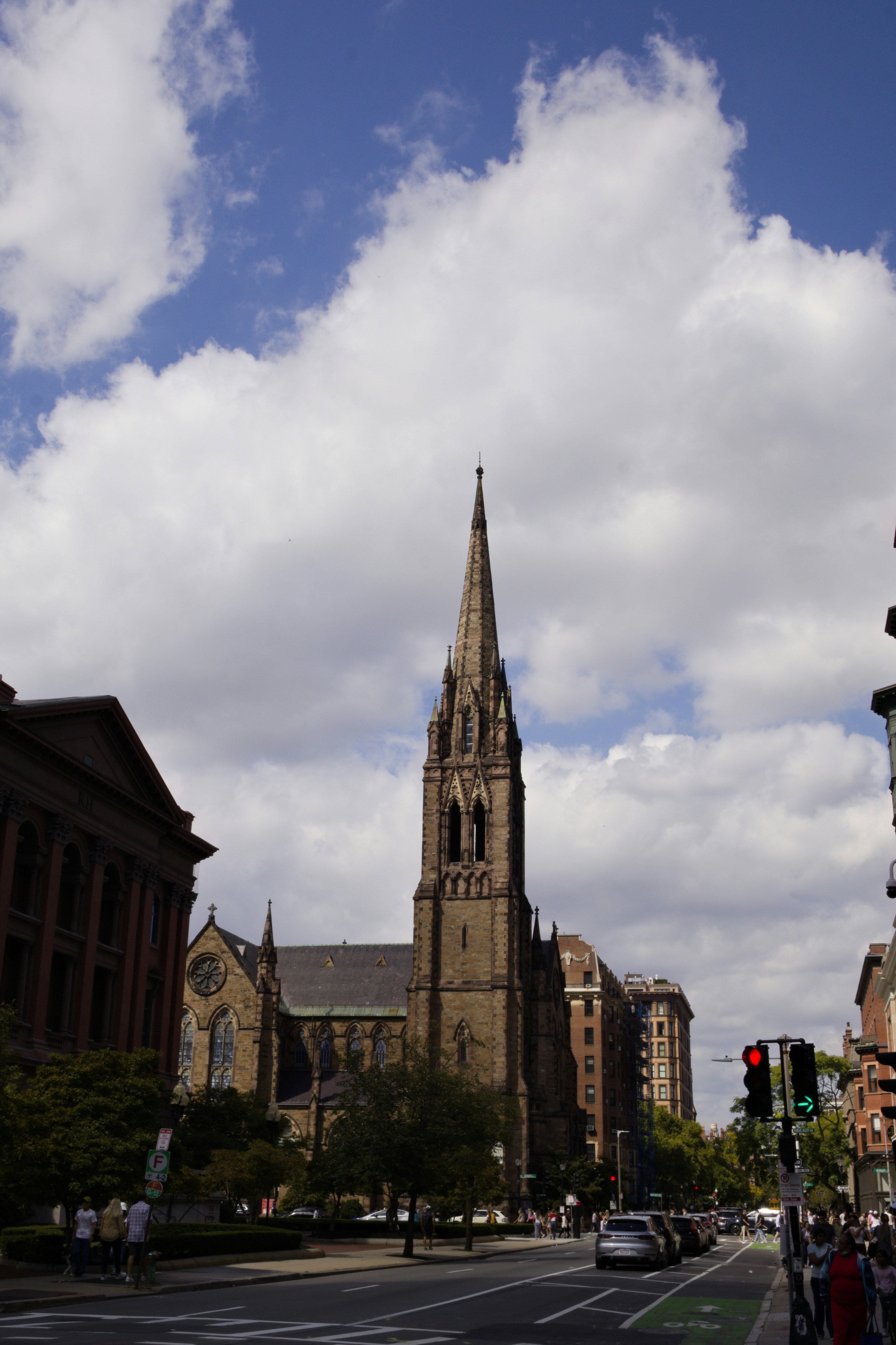 Gothic Spire Above City Street: St. Luke’s Cathedral Under a Dynamic Sky