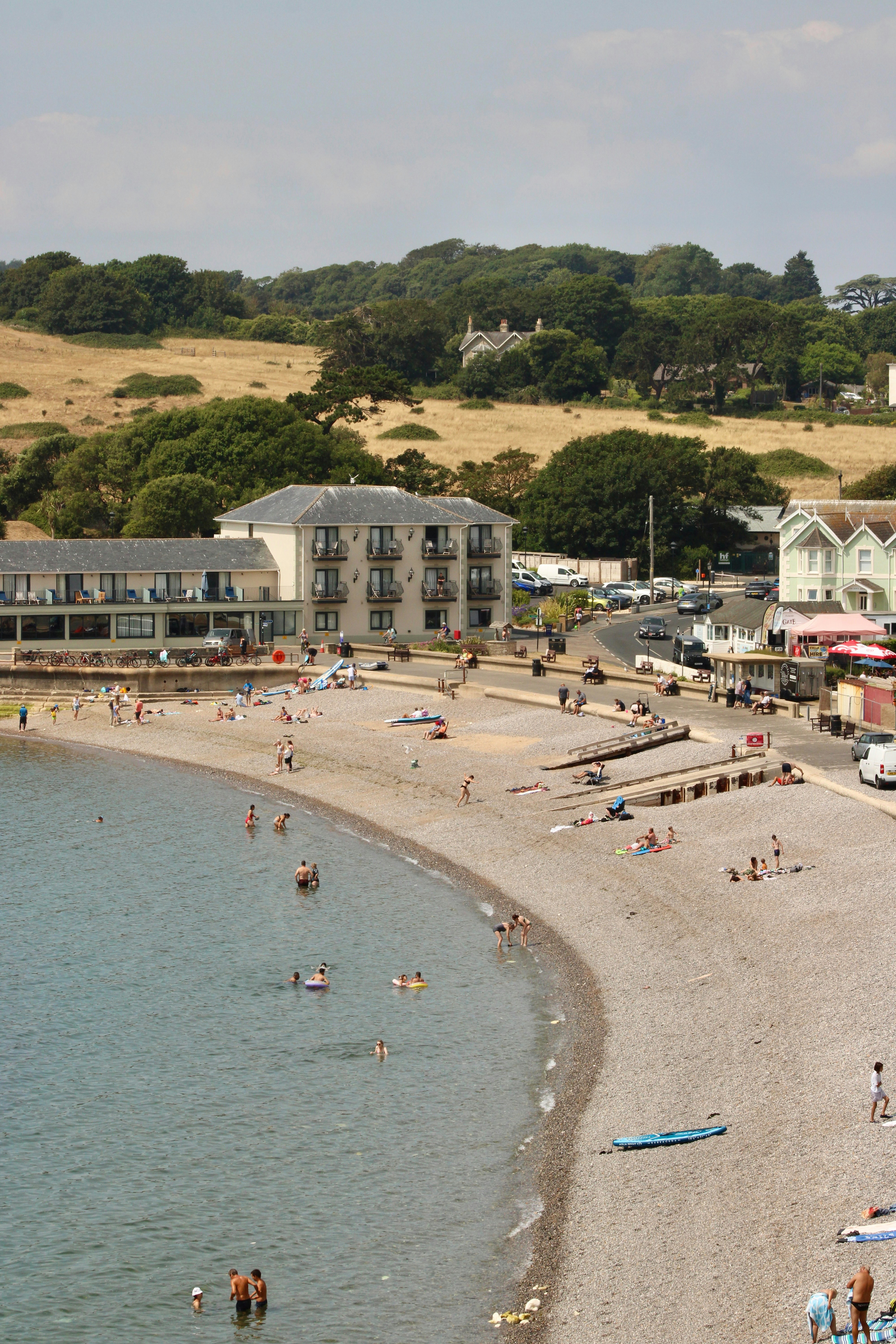 Shoreline Village: Sunlit Beachfront with People and Boats