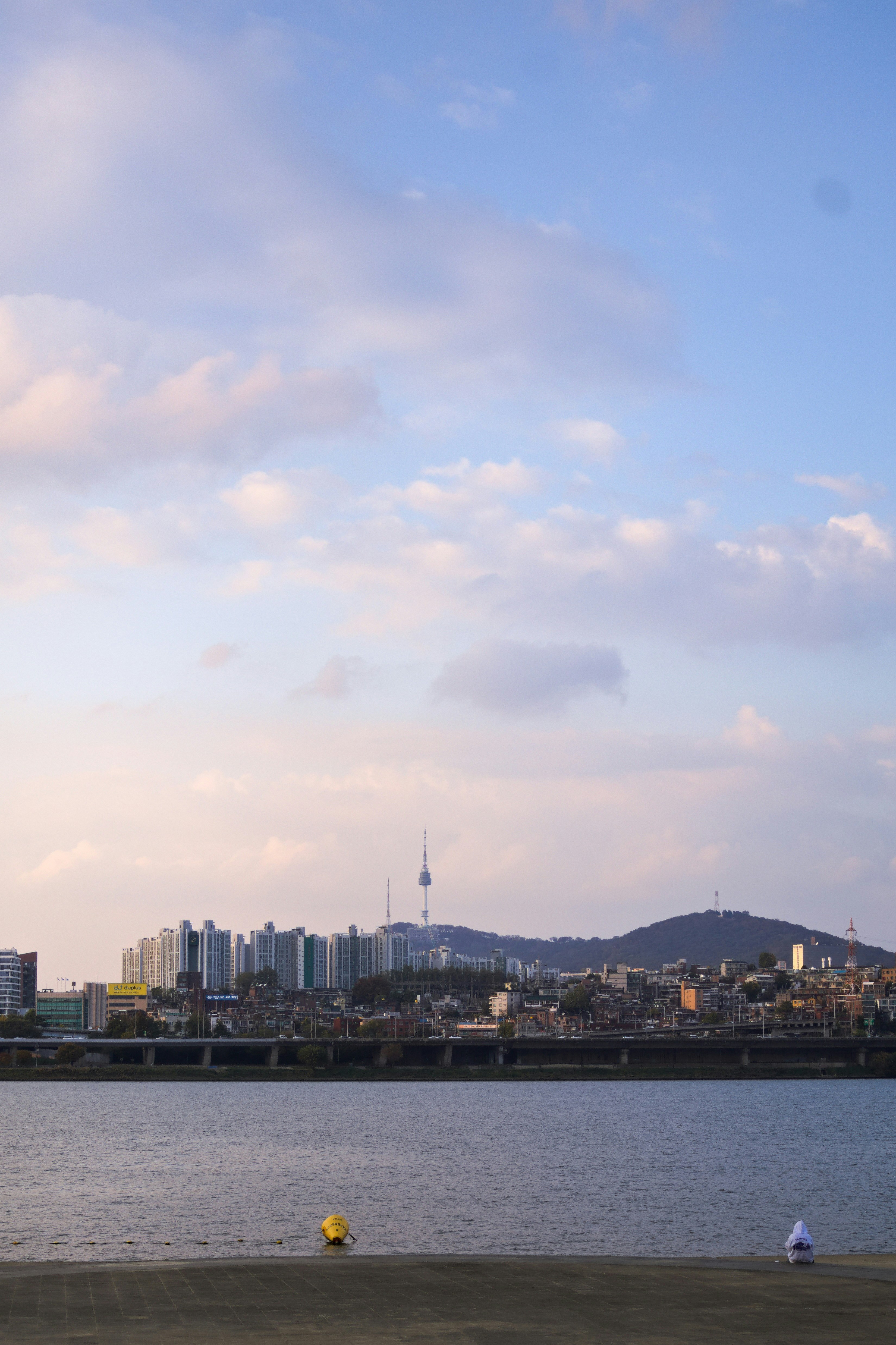 City by the Water at Dusk: Skyscrapers and KTX-like Tower rise over calm harbor