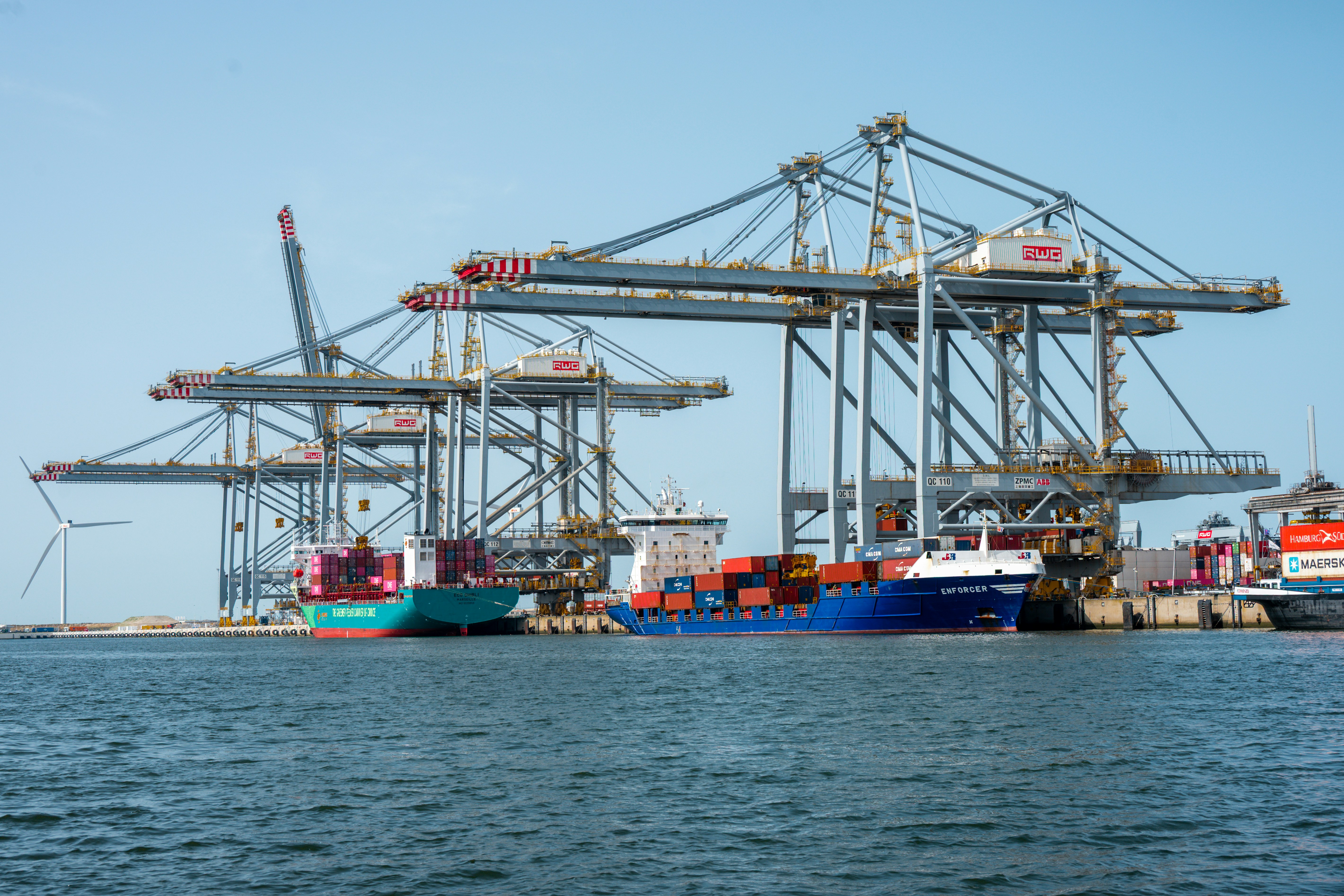 Harbor Giants: Cranes Loom Over a Fleet at Dawn