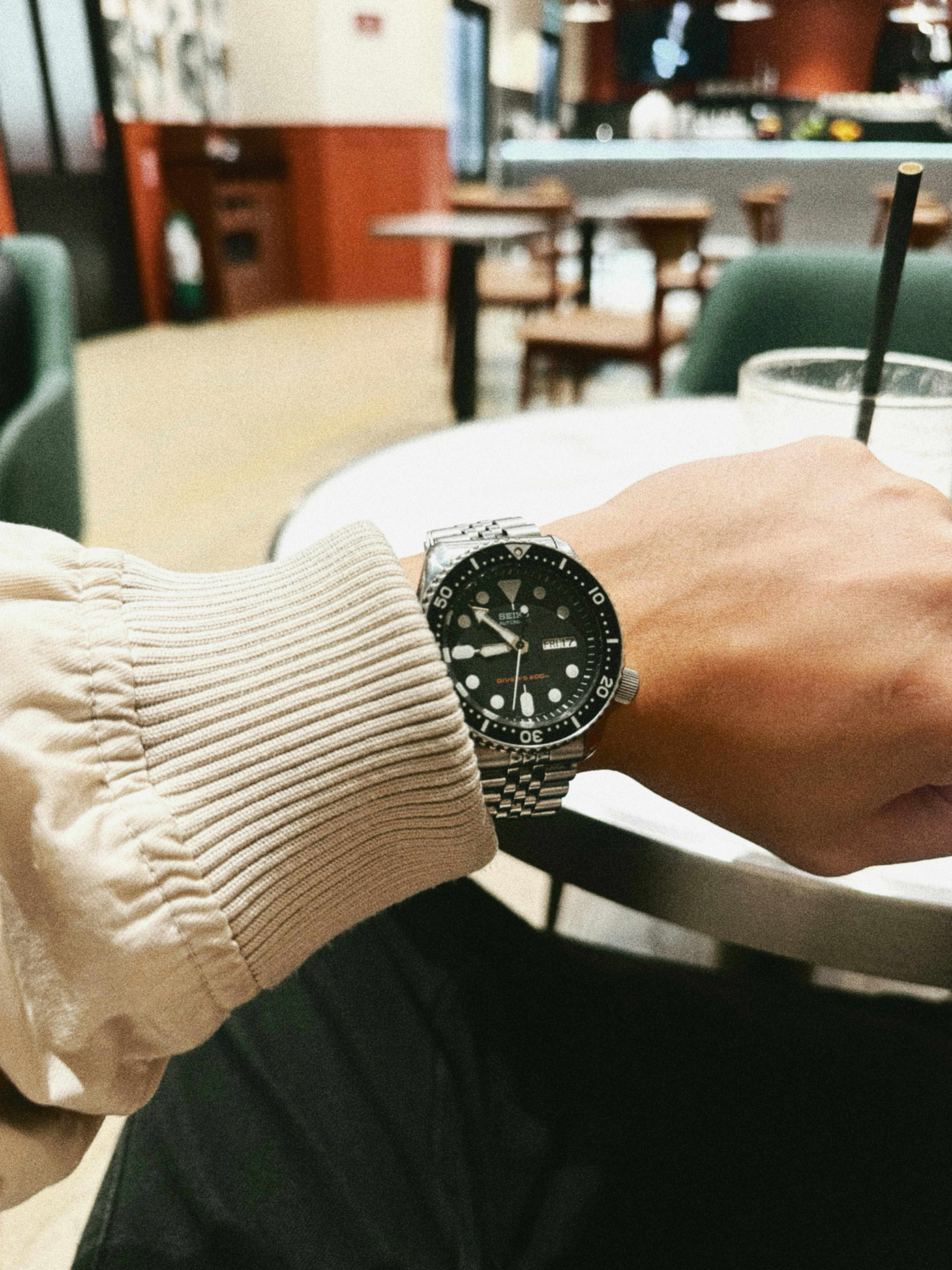 Timepiece at Table: A Casual Moment Highlighted by a Stainless Steel Diver Watch