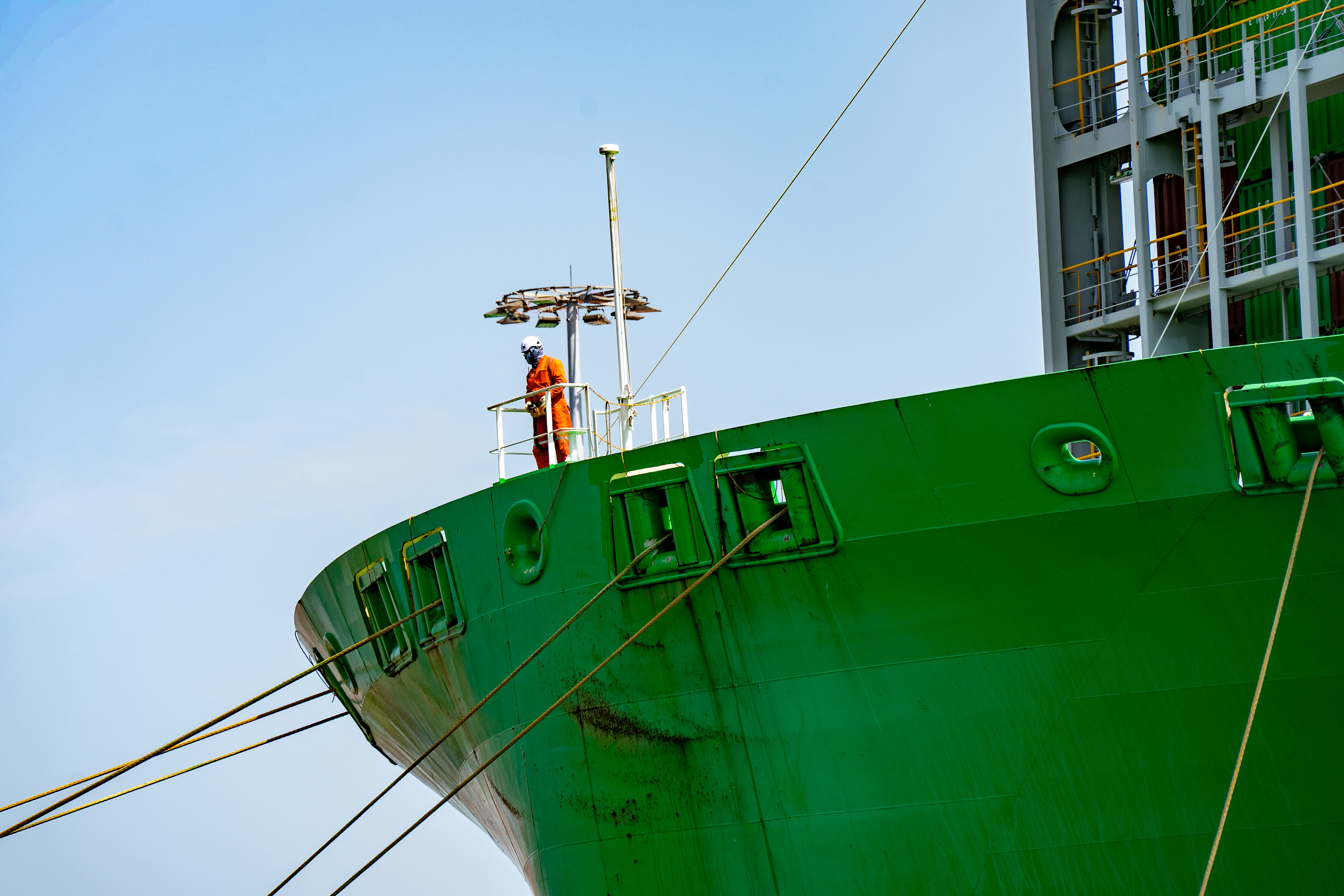 Green Vessel, Quiet Watch: A Worker Guarding the Bow at Dawn