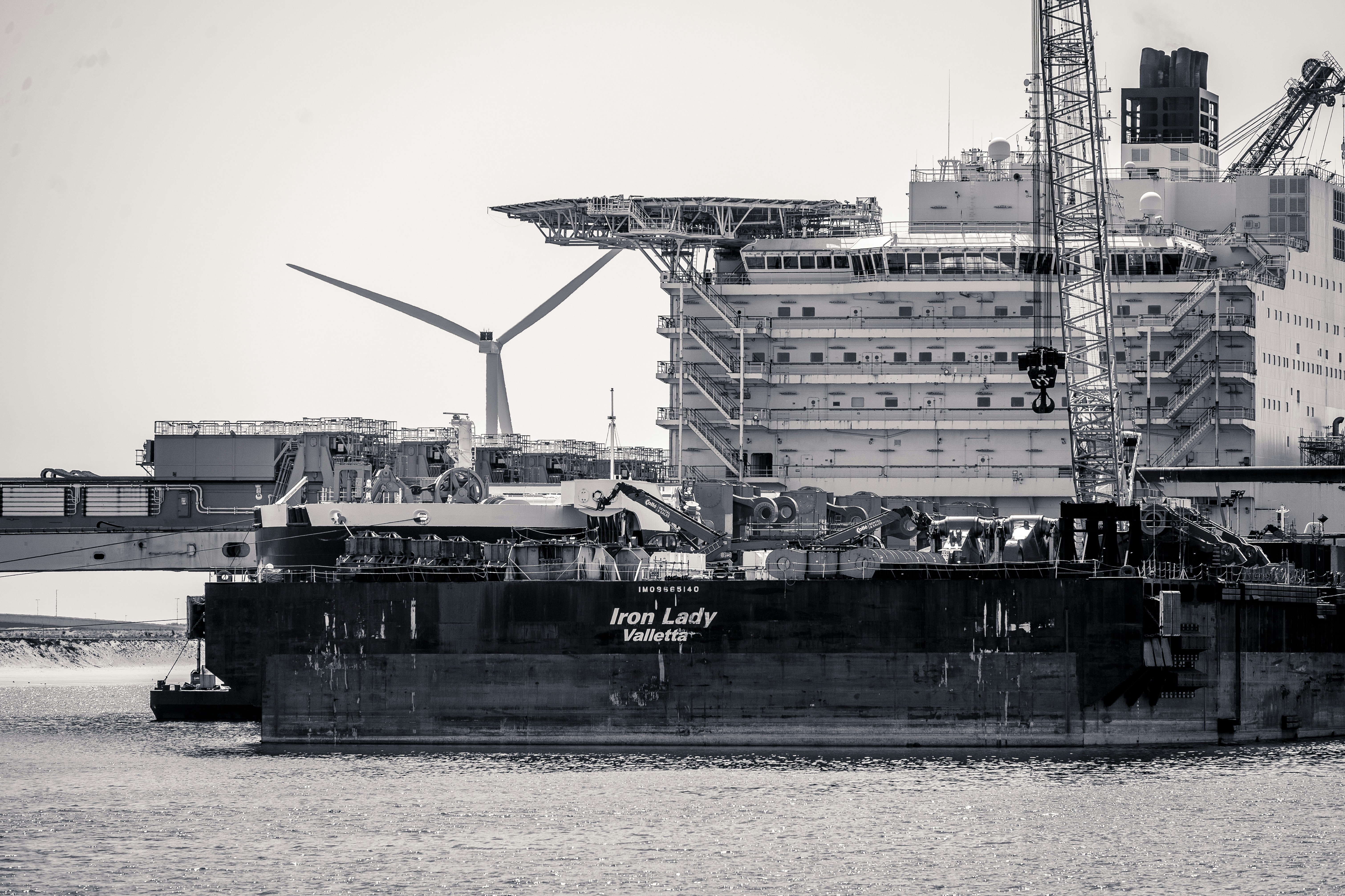 Iron Lady: Harbor Construction from a Dusk-Toned Pier