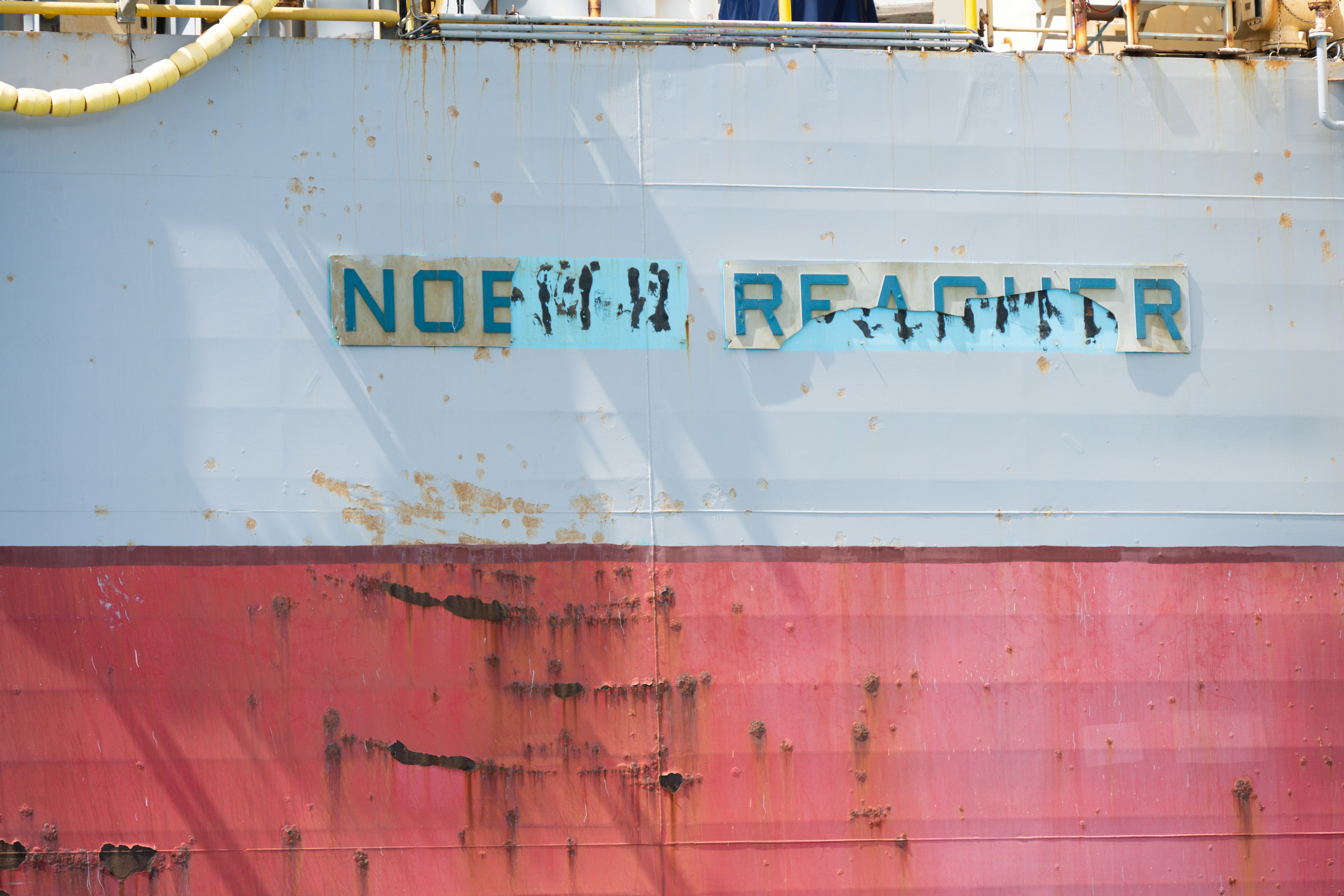 Weathered Deck Sign: Faded Letters Against a Rusty Hull