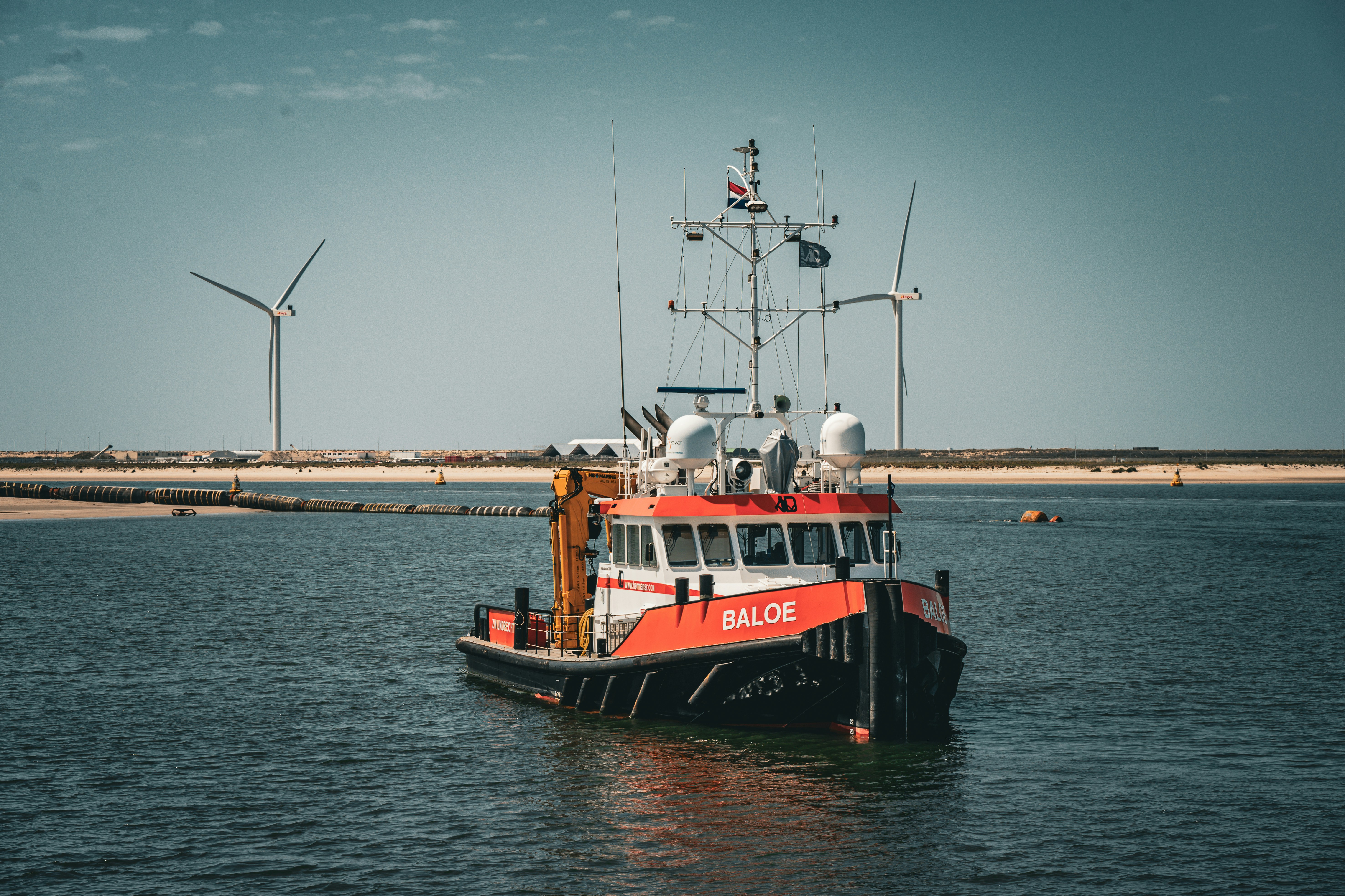 Red-and-White Tugboat Baloe Anchored in Calm Coastal Waters
