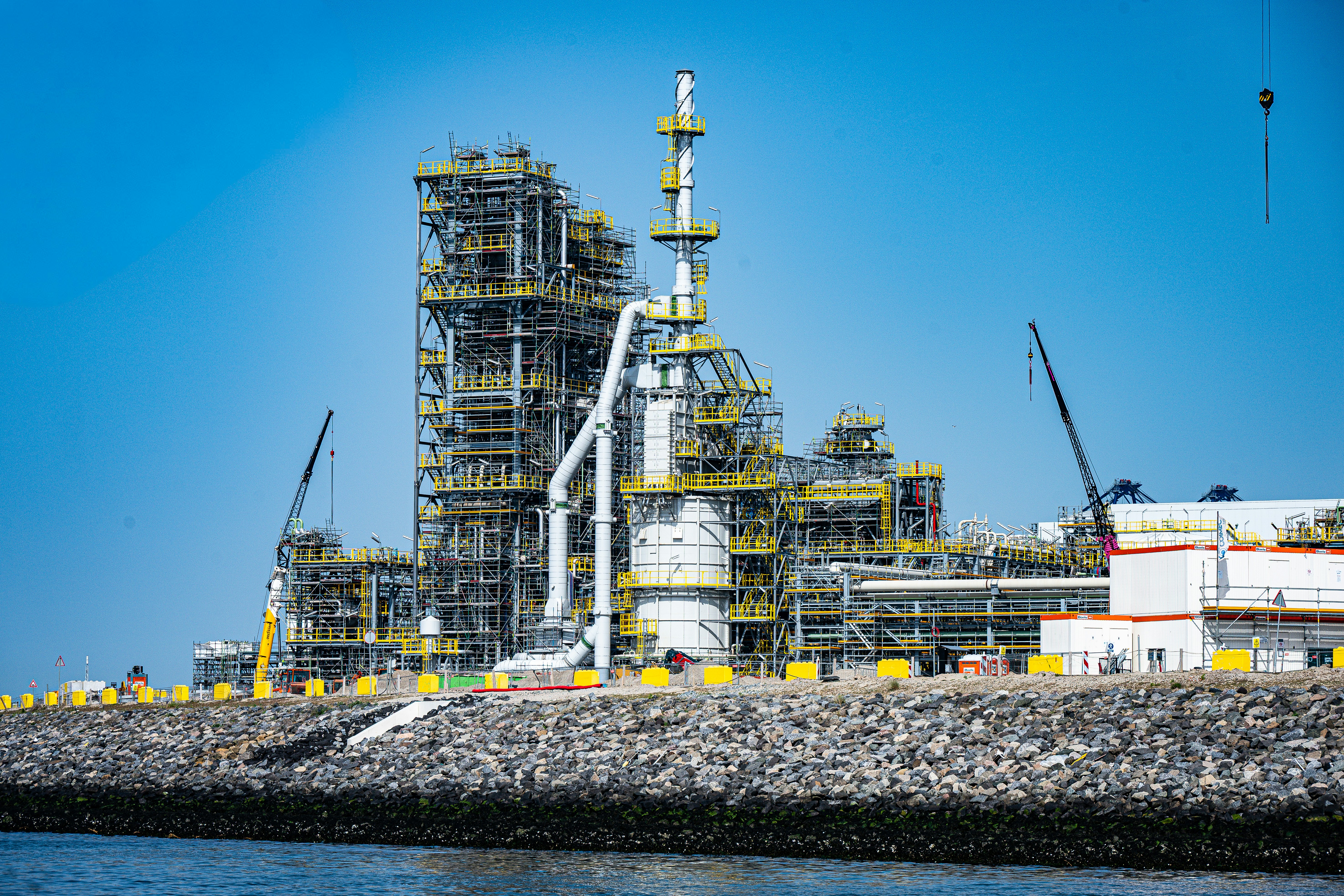Industrial Sentinel: A Coastal refinery Arcing Toward the Sky