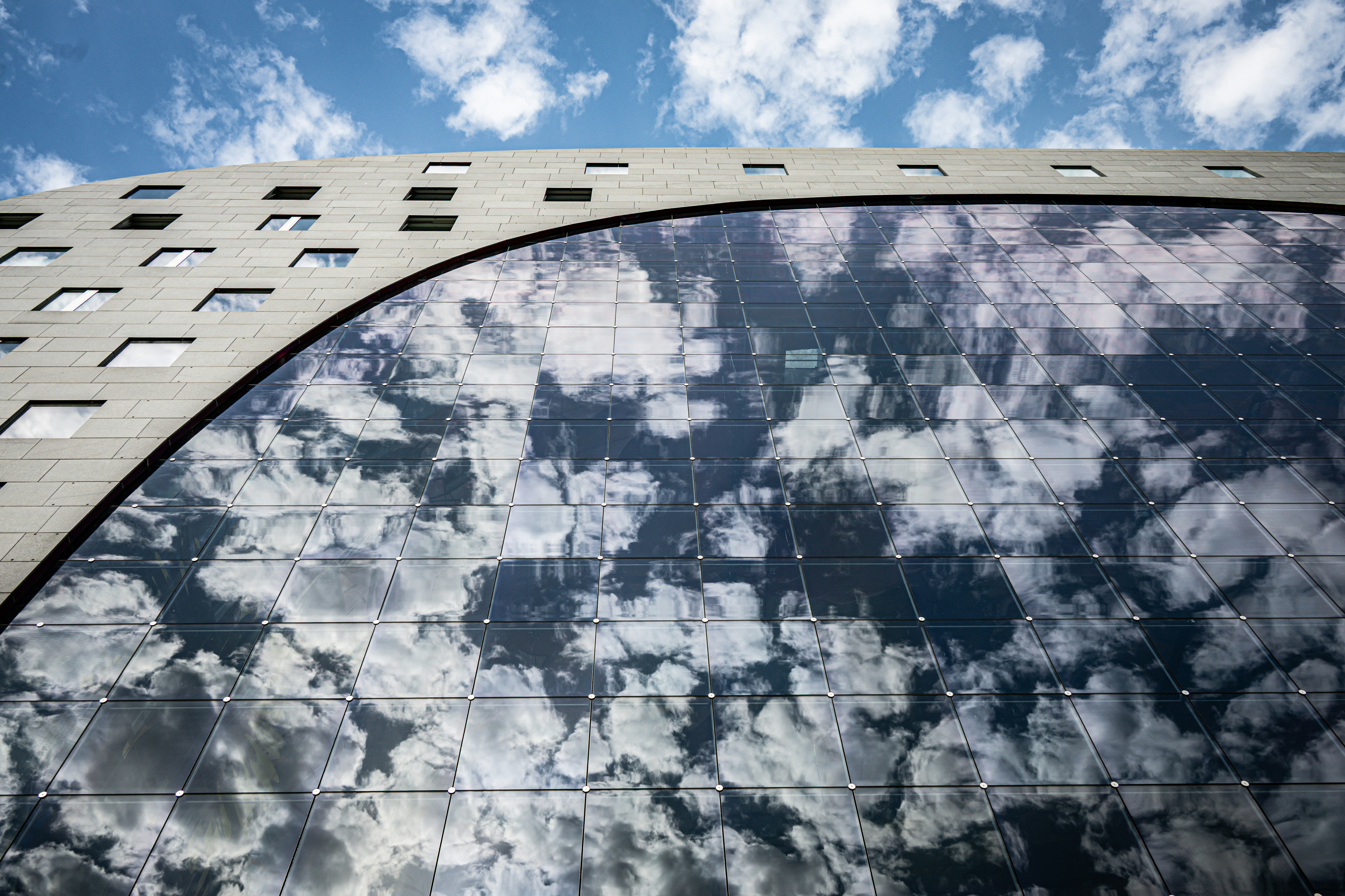 Skyward Facade: A Glass Curve Reflecting the Cloudscape