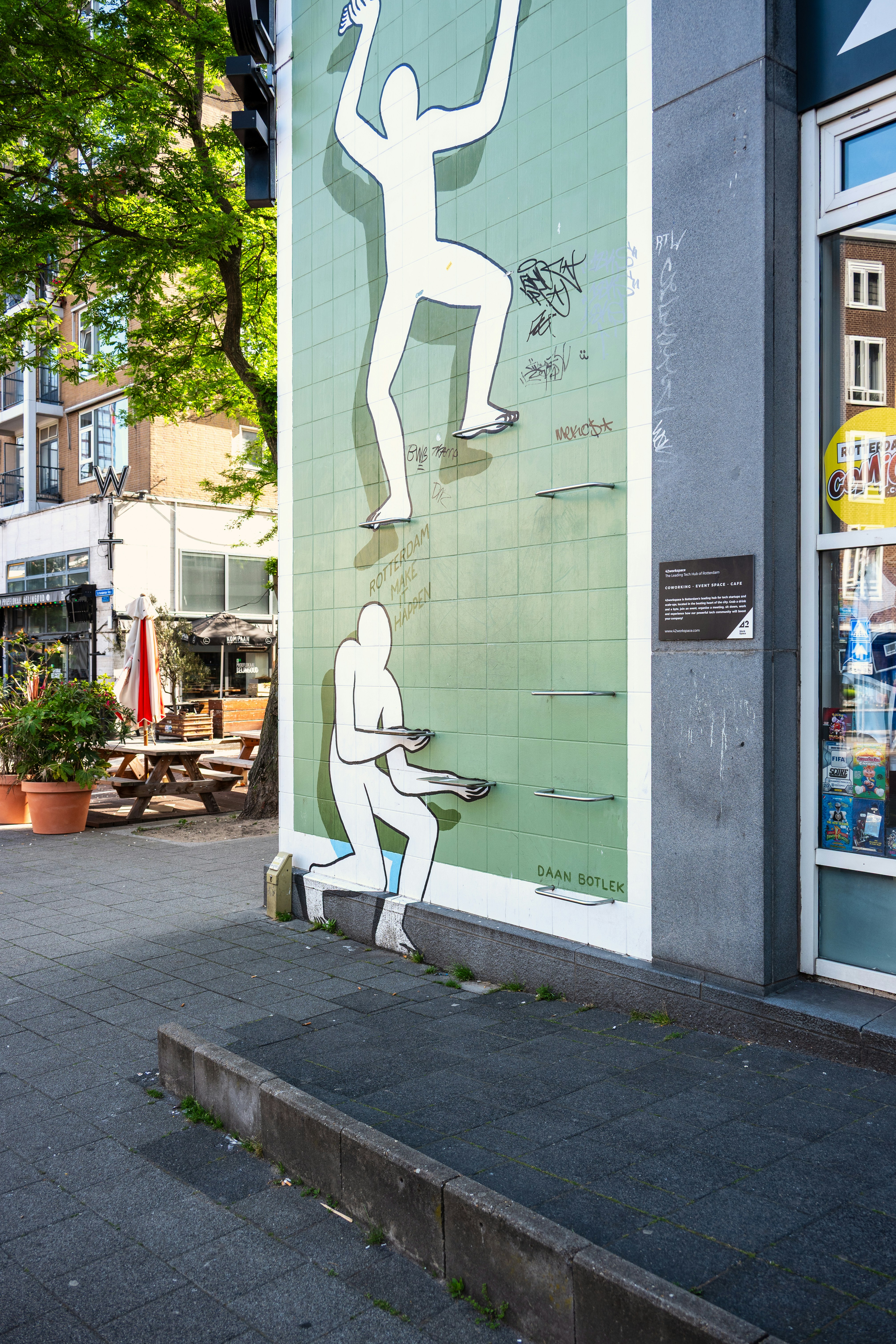 Lifesize Figures Climbing a Green Wall