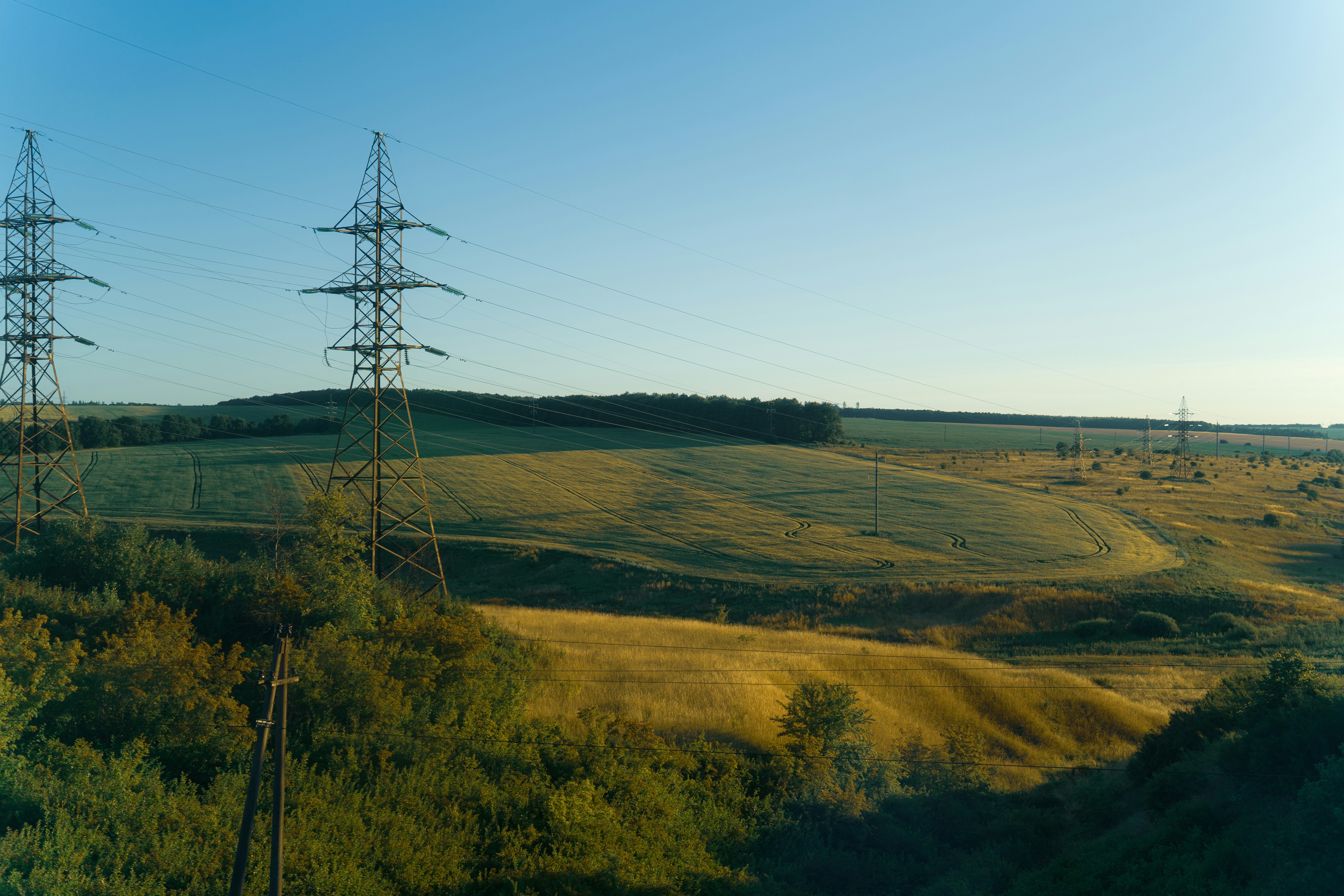 Power Lines Over Rolling Golden Hills at Dusk