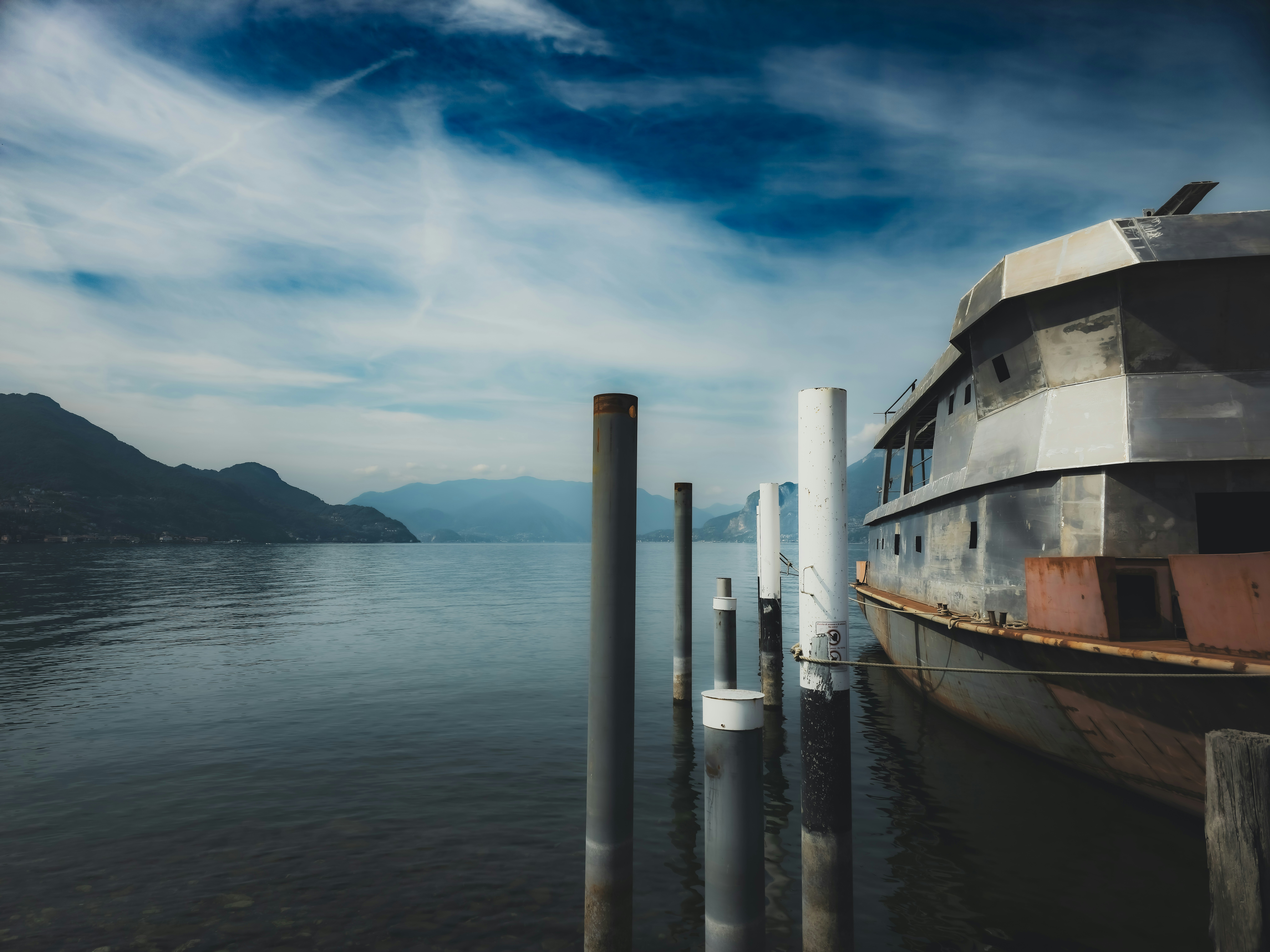Disused Boat Pier Framed by Quiet Lake and Distant Mountains