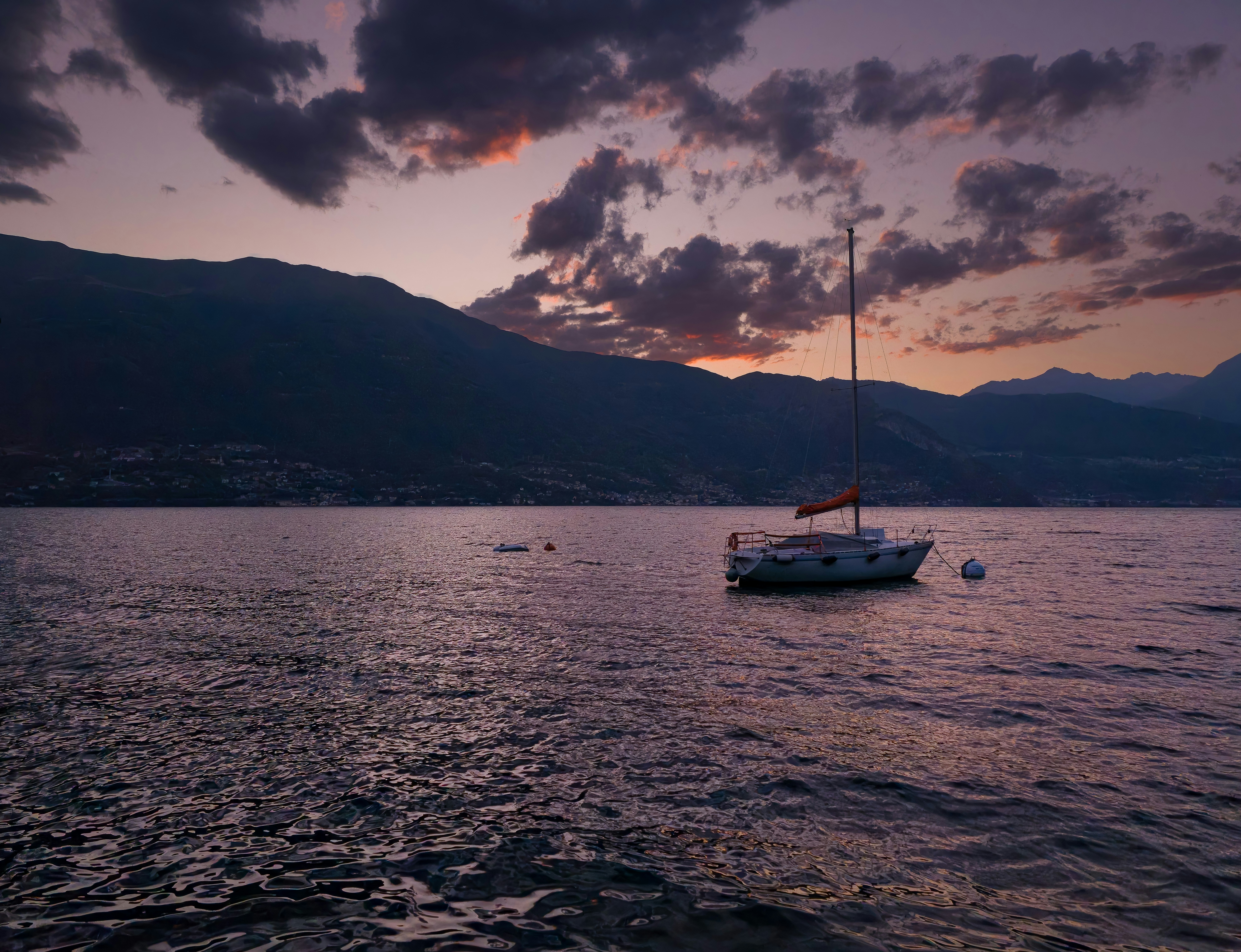 Sailboat Silhouette Against Twilight Mountain Shore
