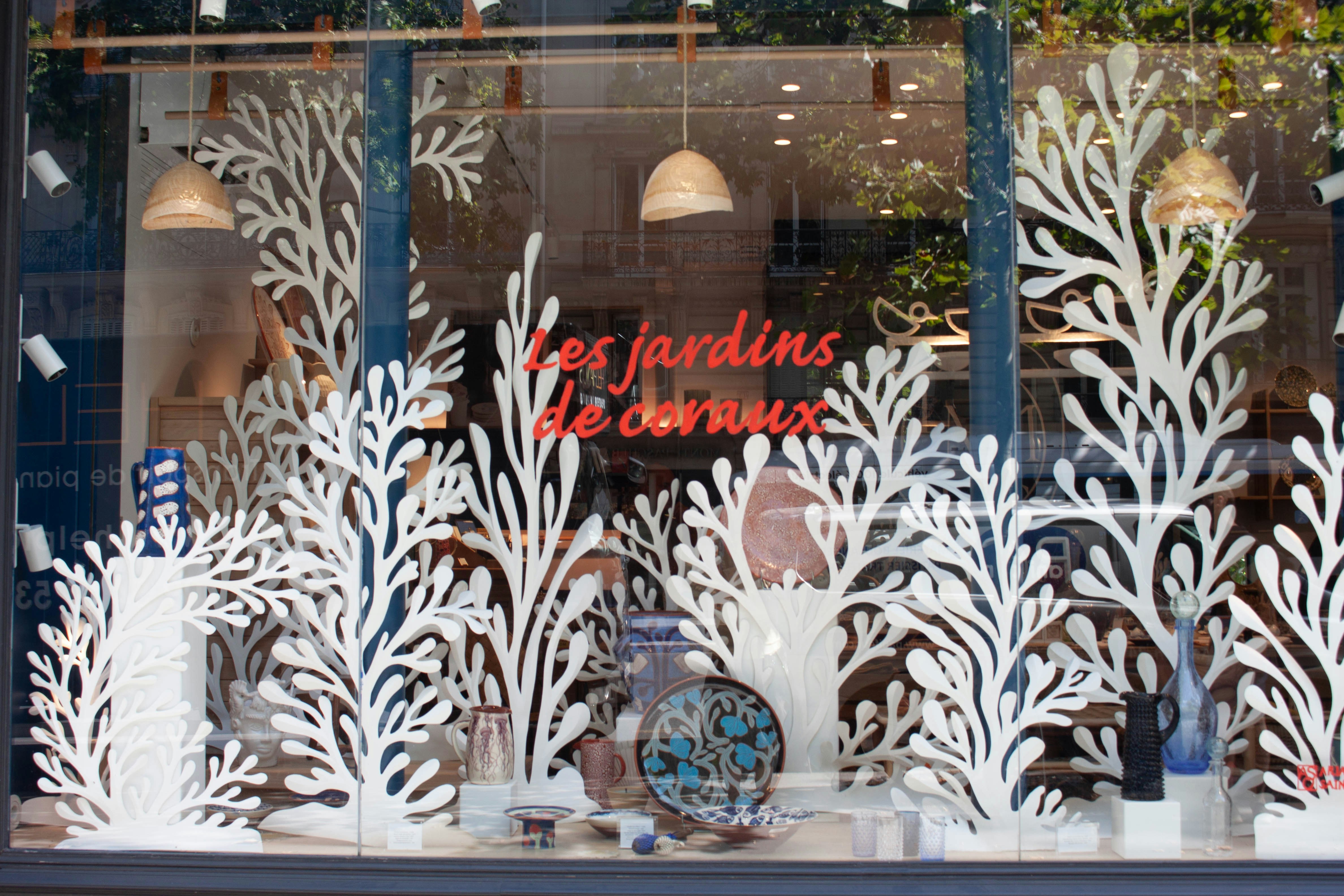 White botanical lattice storefront reveals a red script centerpiece