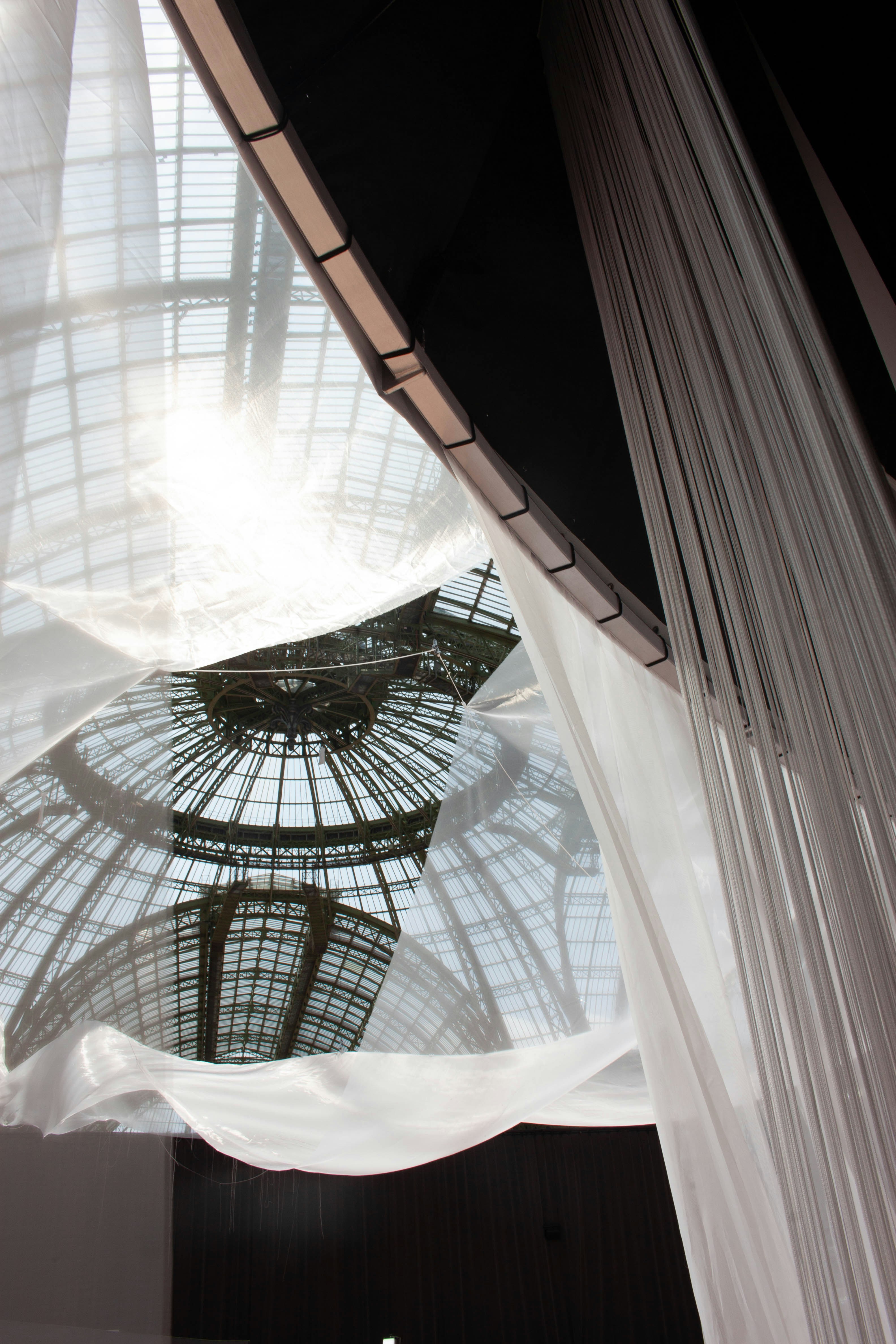 Curtains of Light: A Glass-ceilinged Venue Framed by Floating Drapes