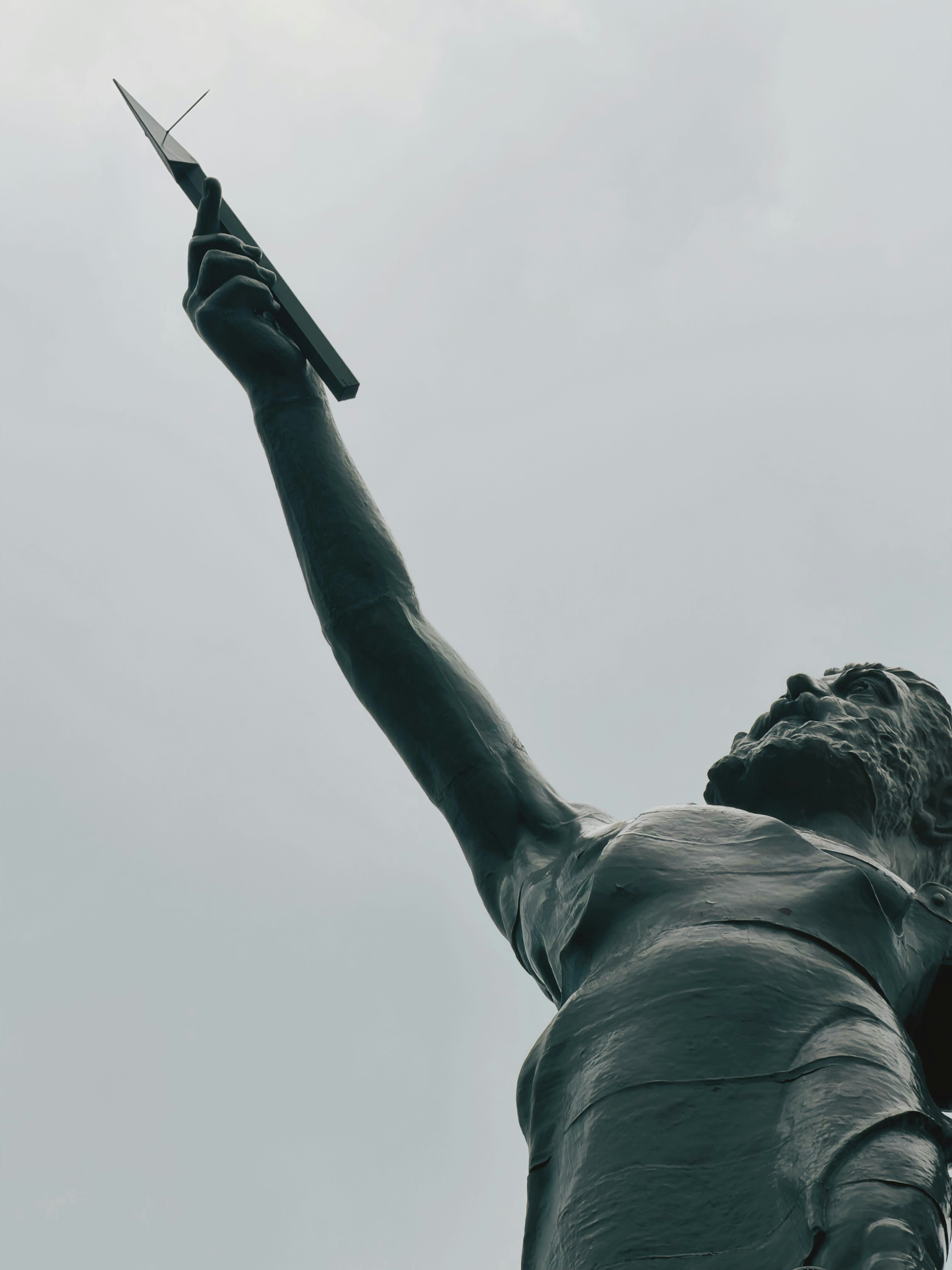 Raising Hope: A Statue Reaches Toward the Sky with a Scythe-like Blade