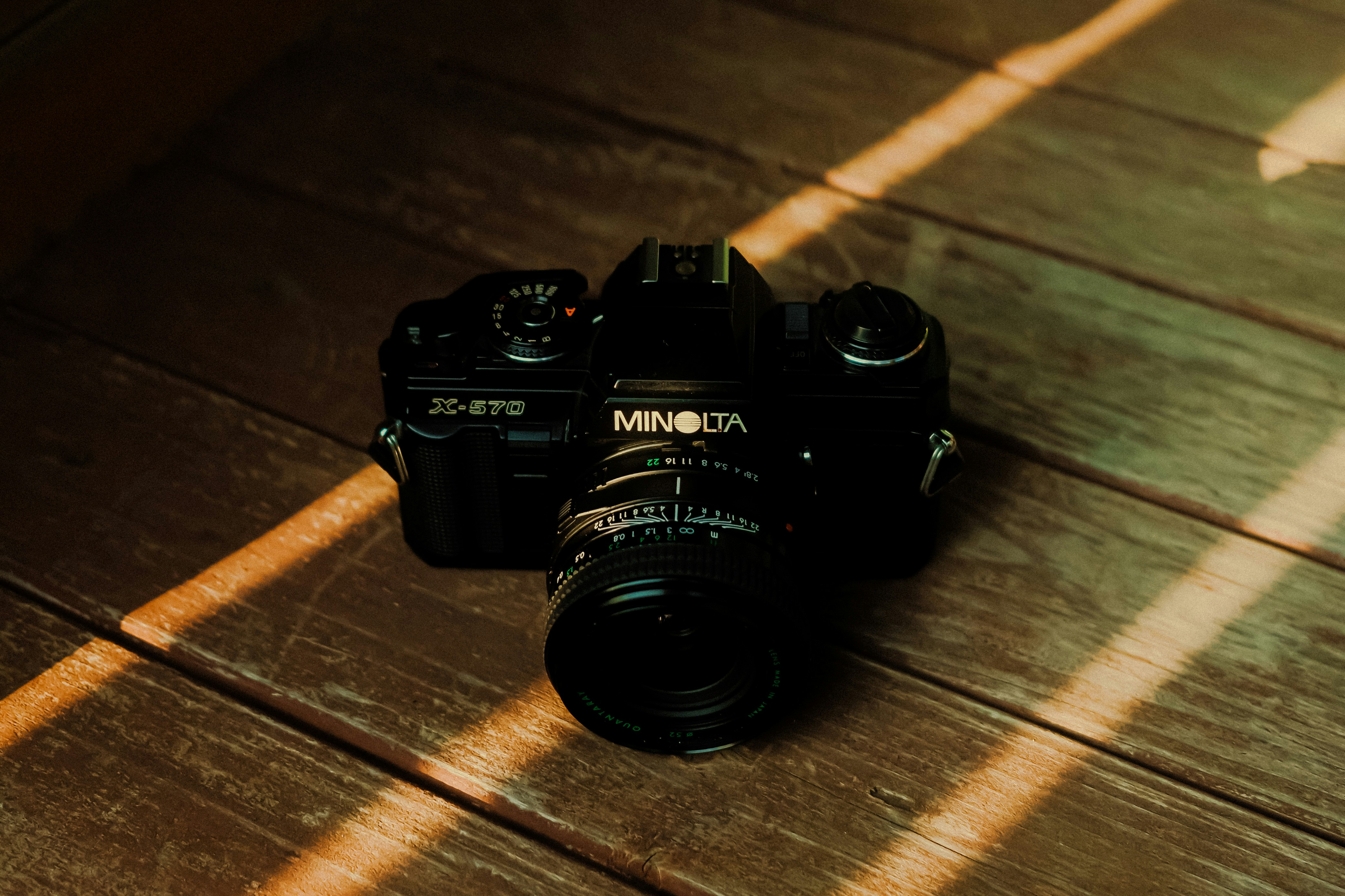 Midnight Shadow: A Vintage Minolta Resting on Weathered Planks