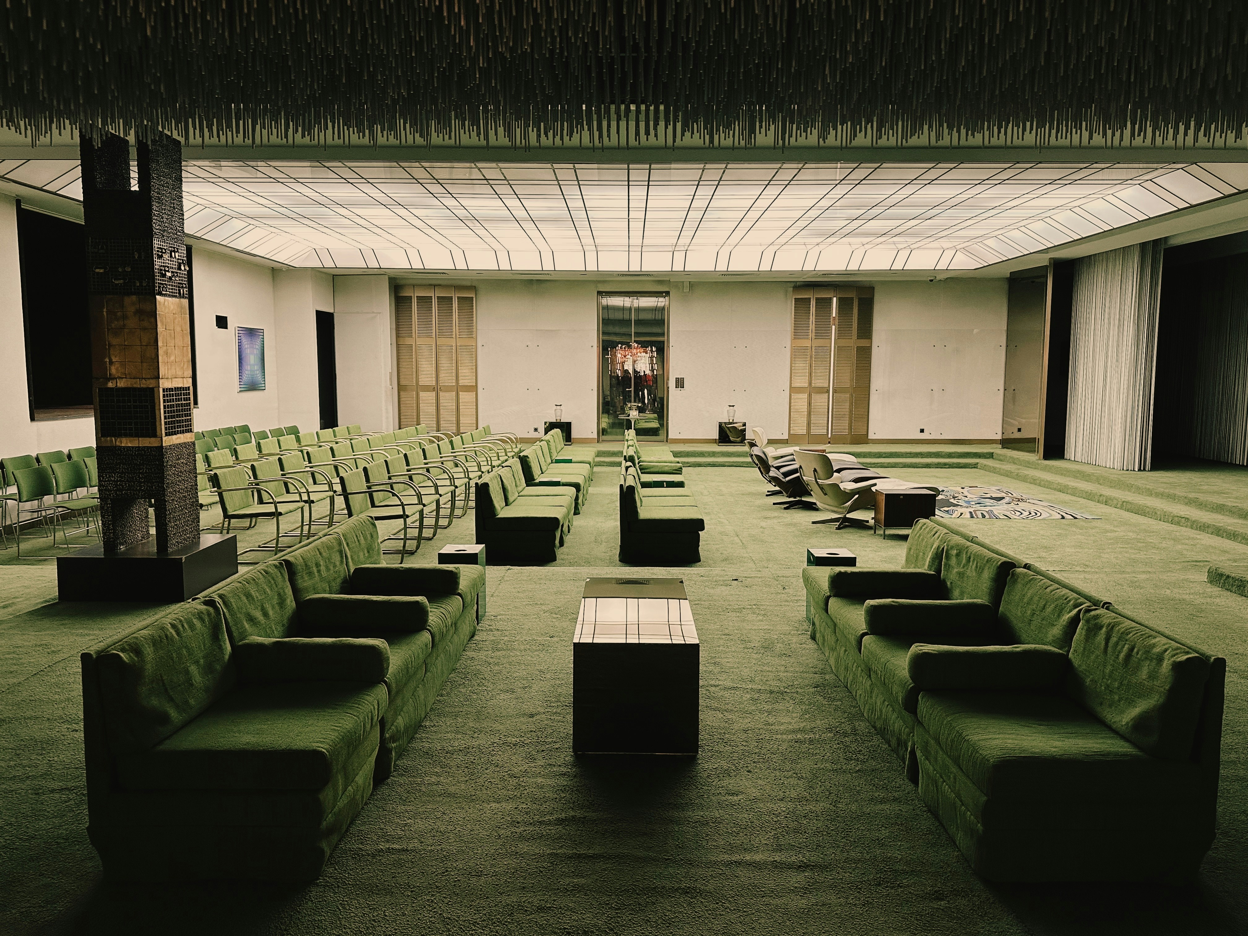 Empty Green Room: Symmetrical Seating Framed by Central Corridor in an Auditorium