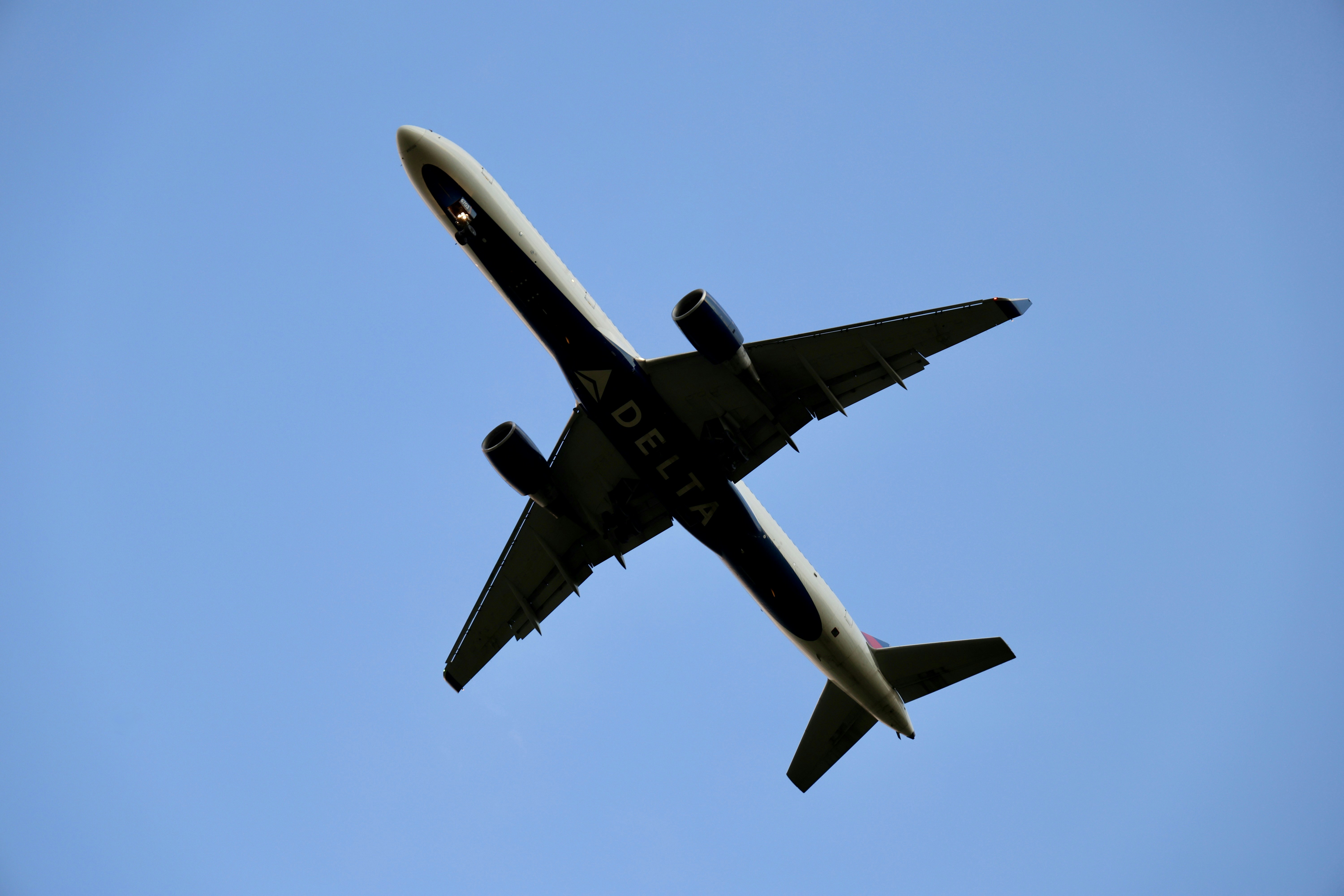 Midflight silhouette: a twin-engine jet slices the blue