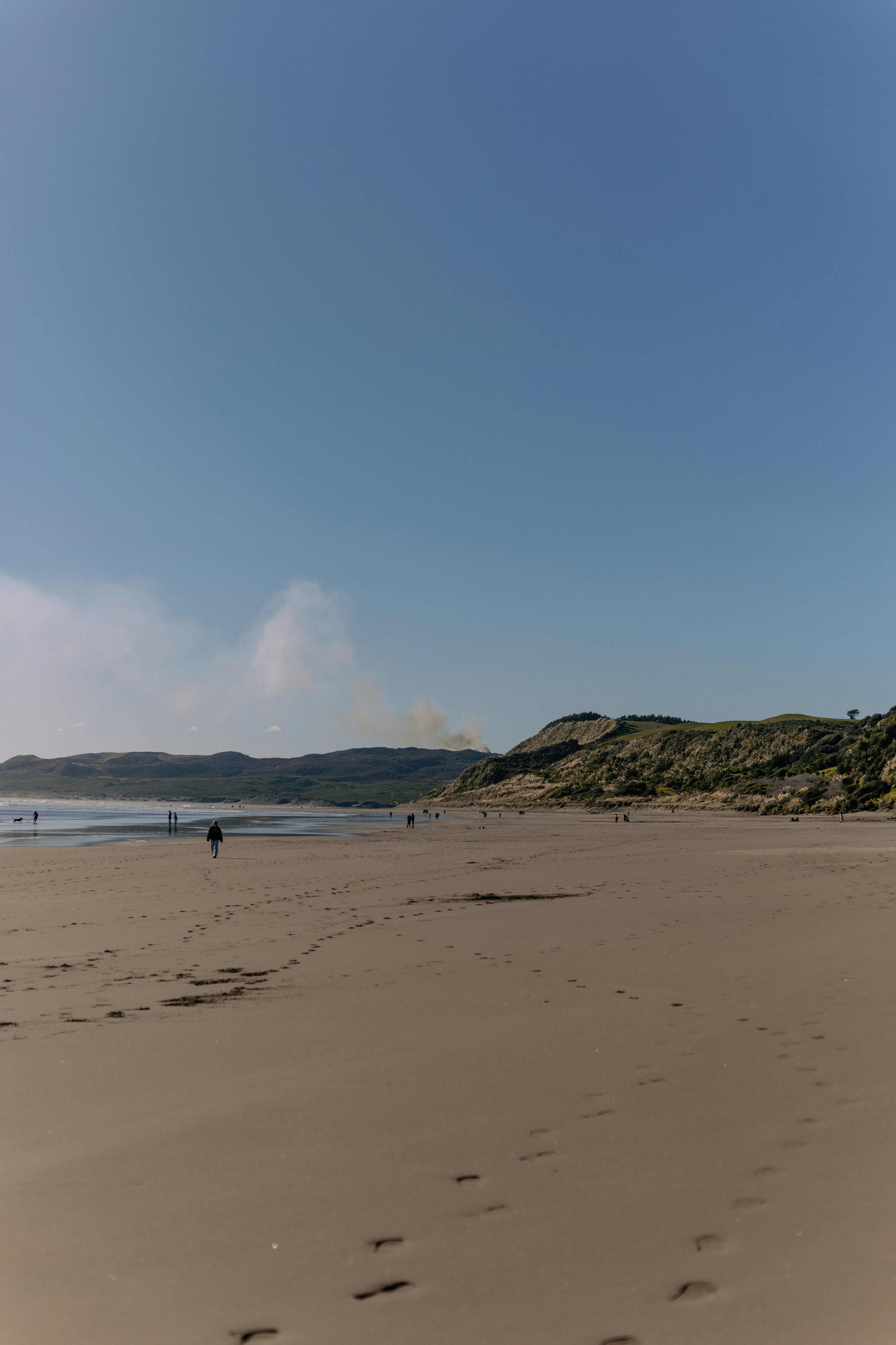 Footprints to the Horizon: A Quiet Beach Day Under Wide Blue Skies