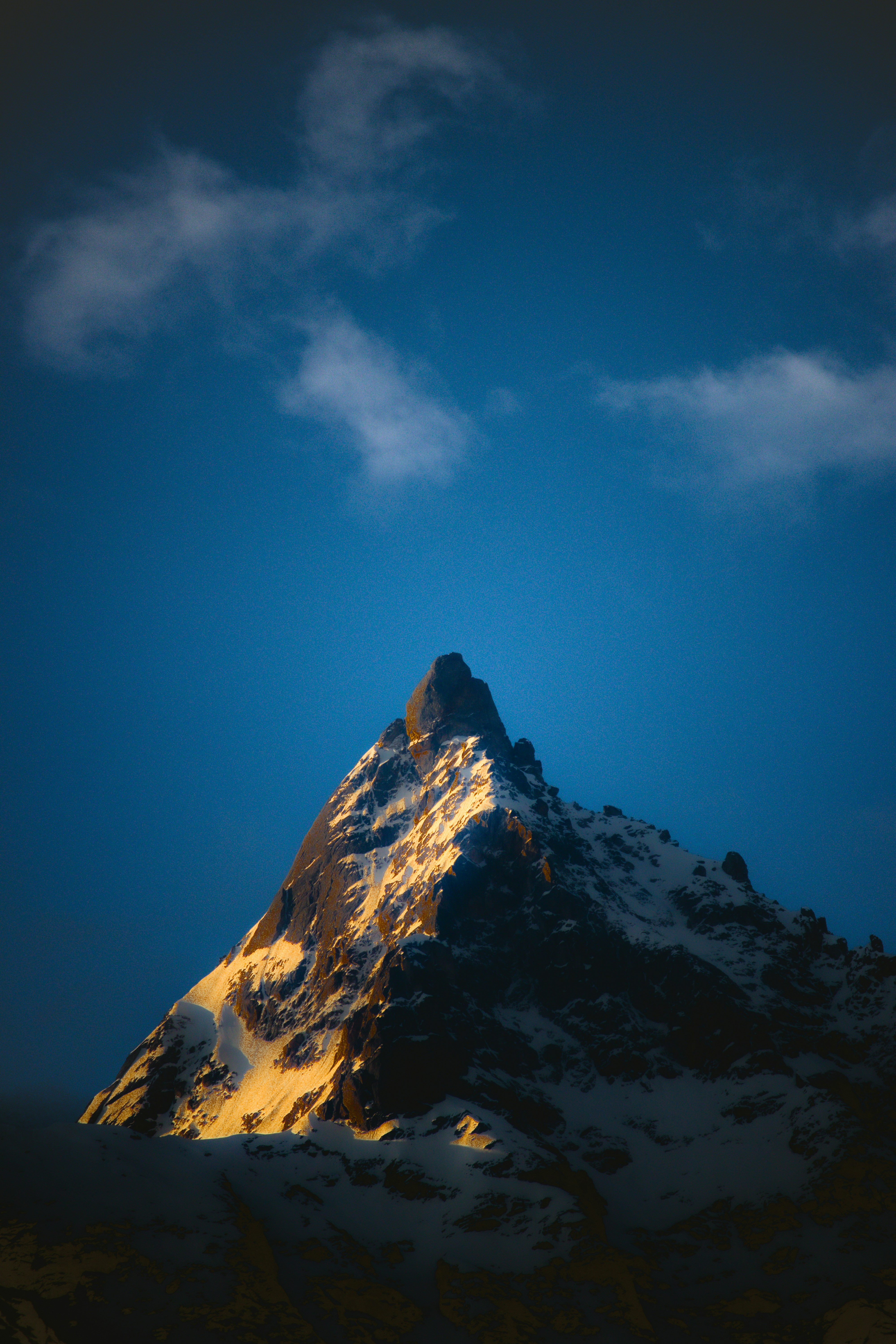 Sunlit Summit: The Lightning Peak Rises Over a Twilight Fjord