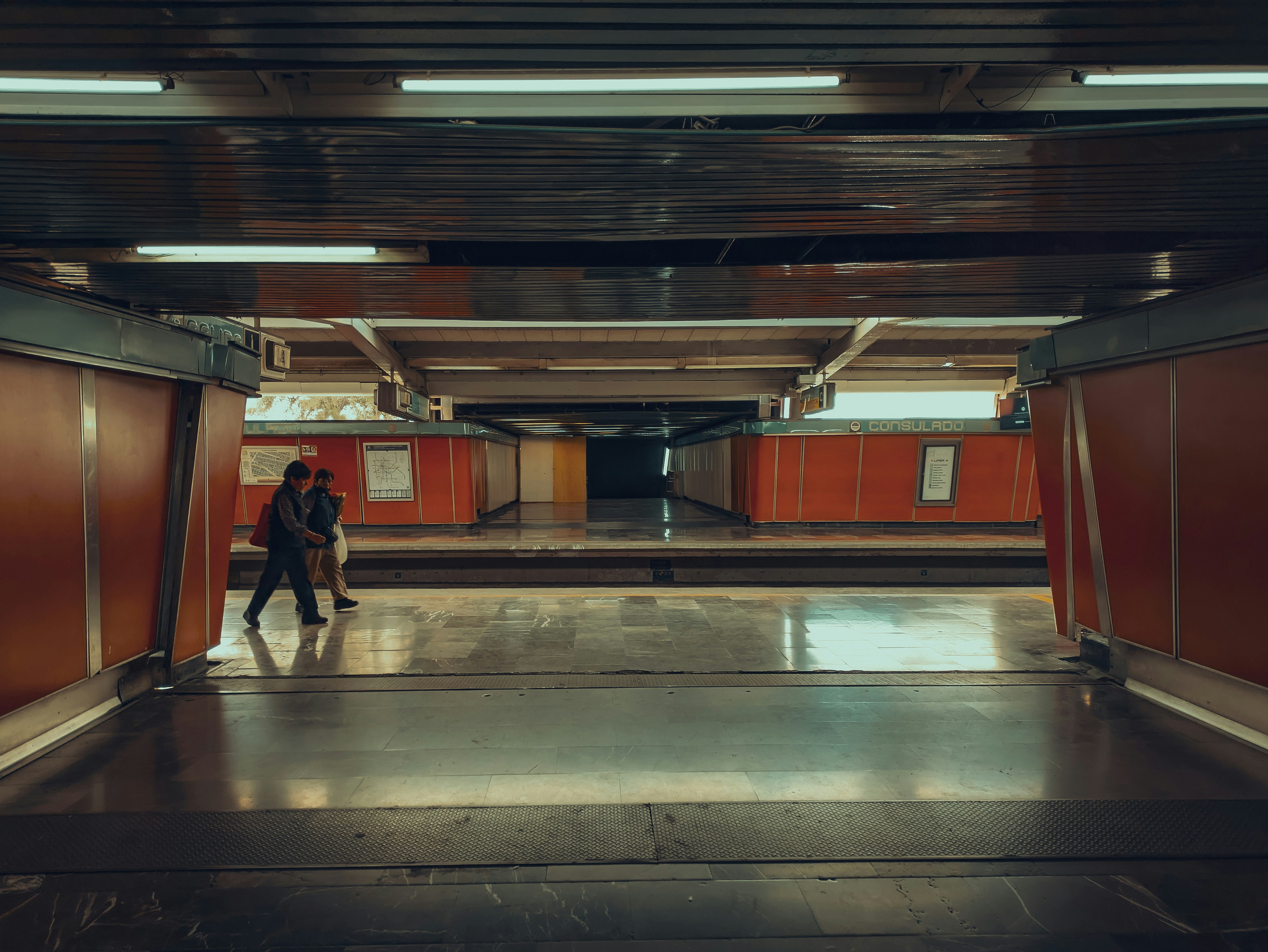 Two Commuters Crossing an Echoing Subway Concourse