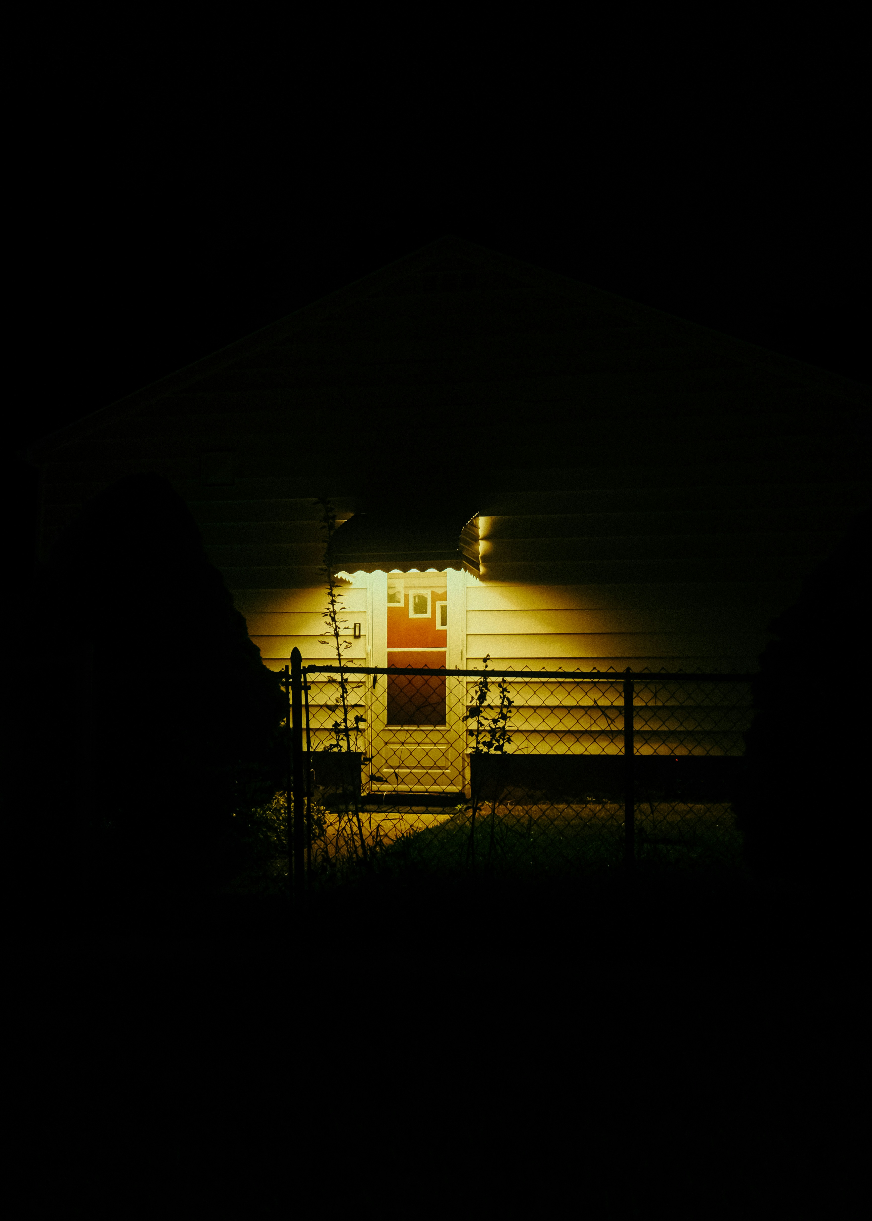 Front Door in Amber Glow: Nighttime Quiet Behind the Fence
