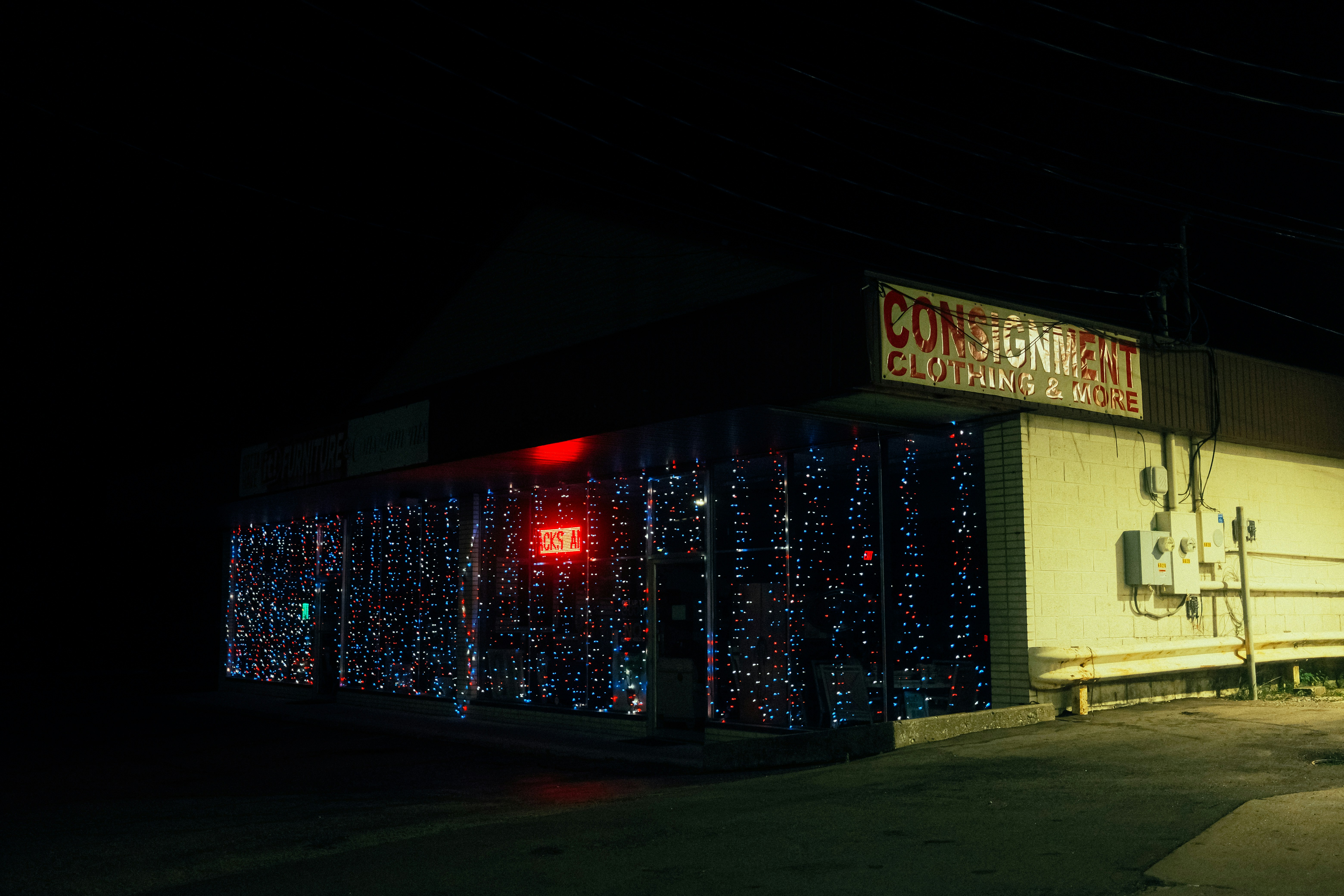 Neon Veil on a Quiet Night: Lights Strung Across a Closed Shop