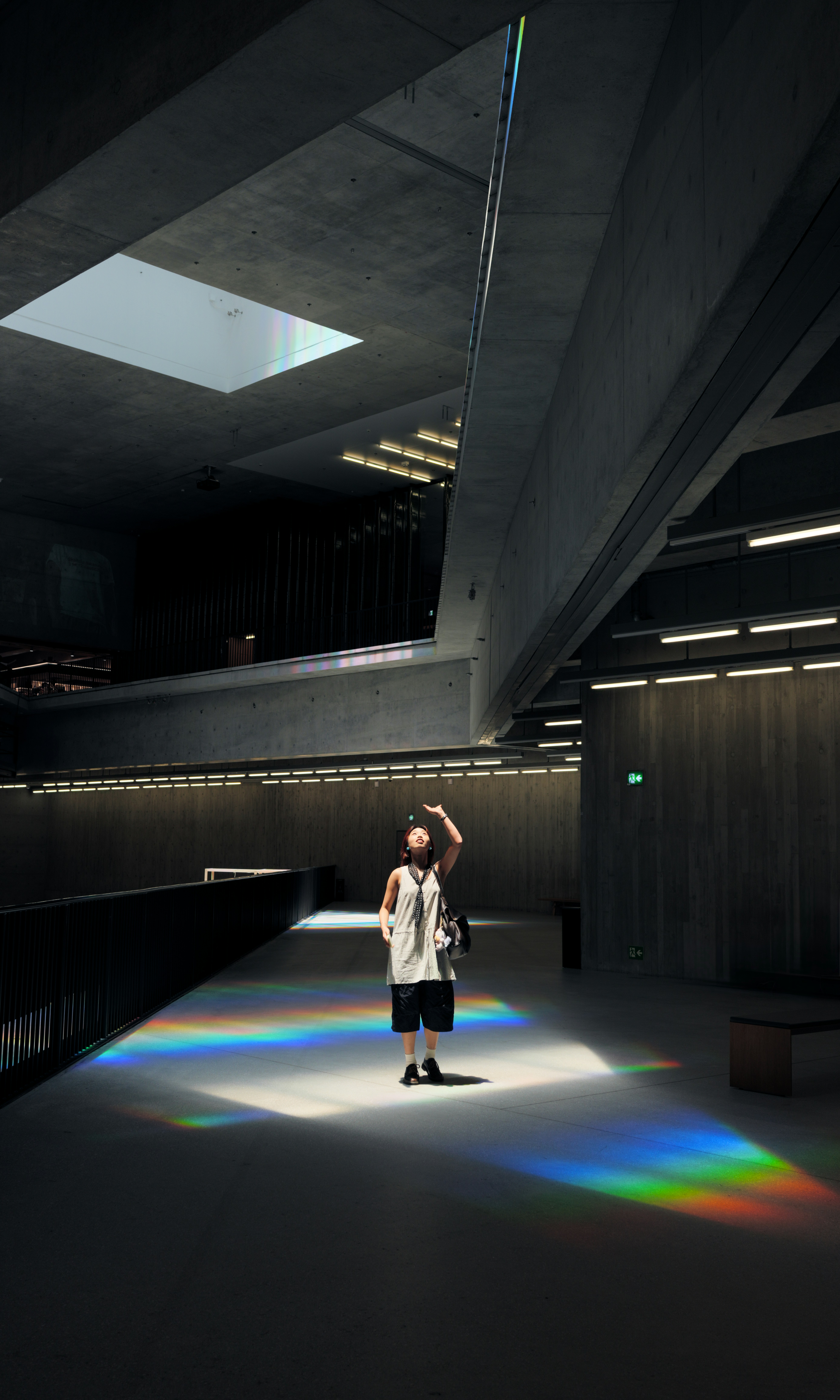 Rainbow Spotlight: A Solo Explorer Under Colored Light in Concrete Architecture