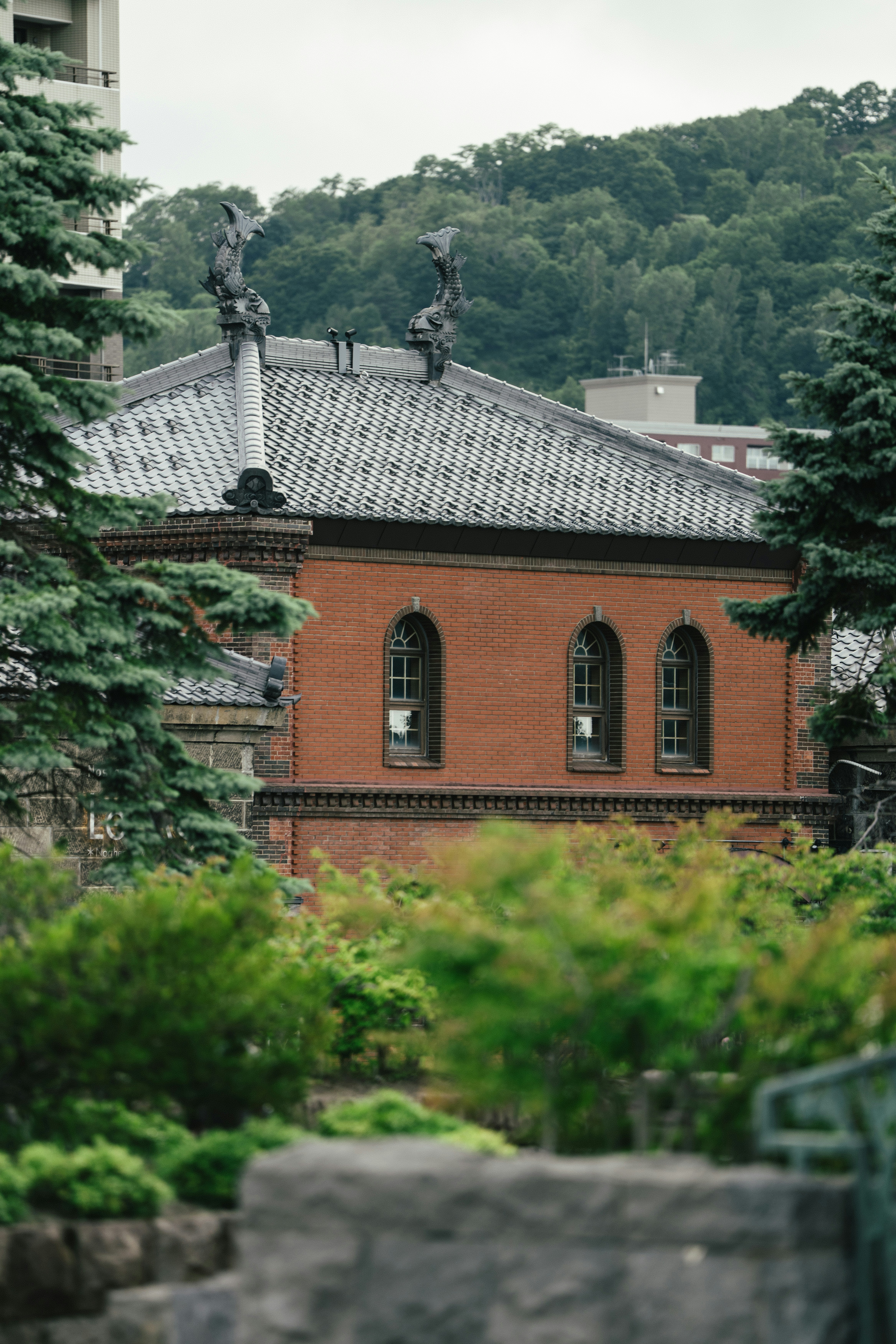 Brick Belle Époque: Aclassic red-brick building framed by green calm