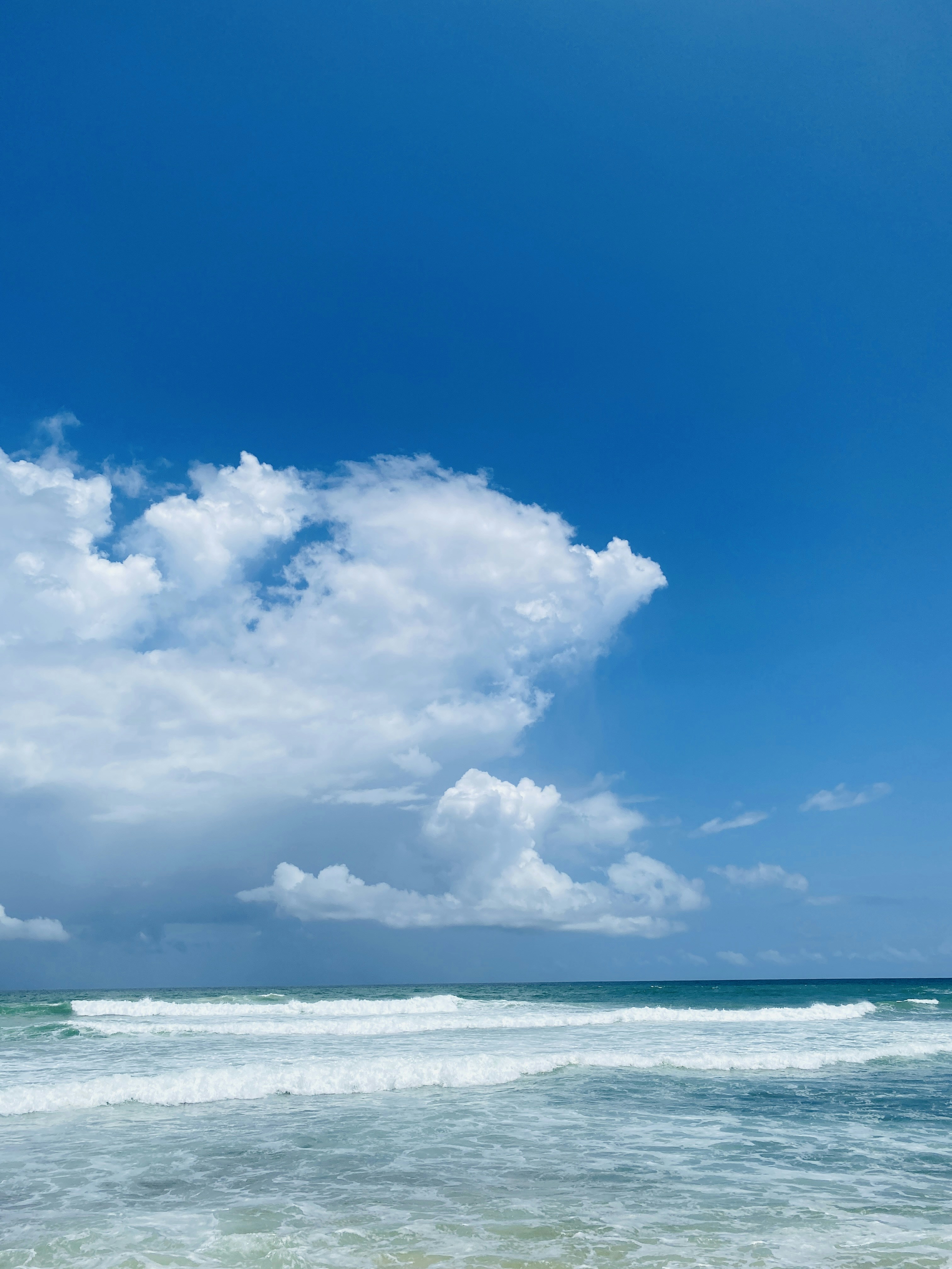 Bottom Edge of the Sky: Calm Sea and billowy clouds