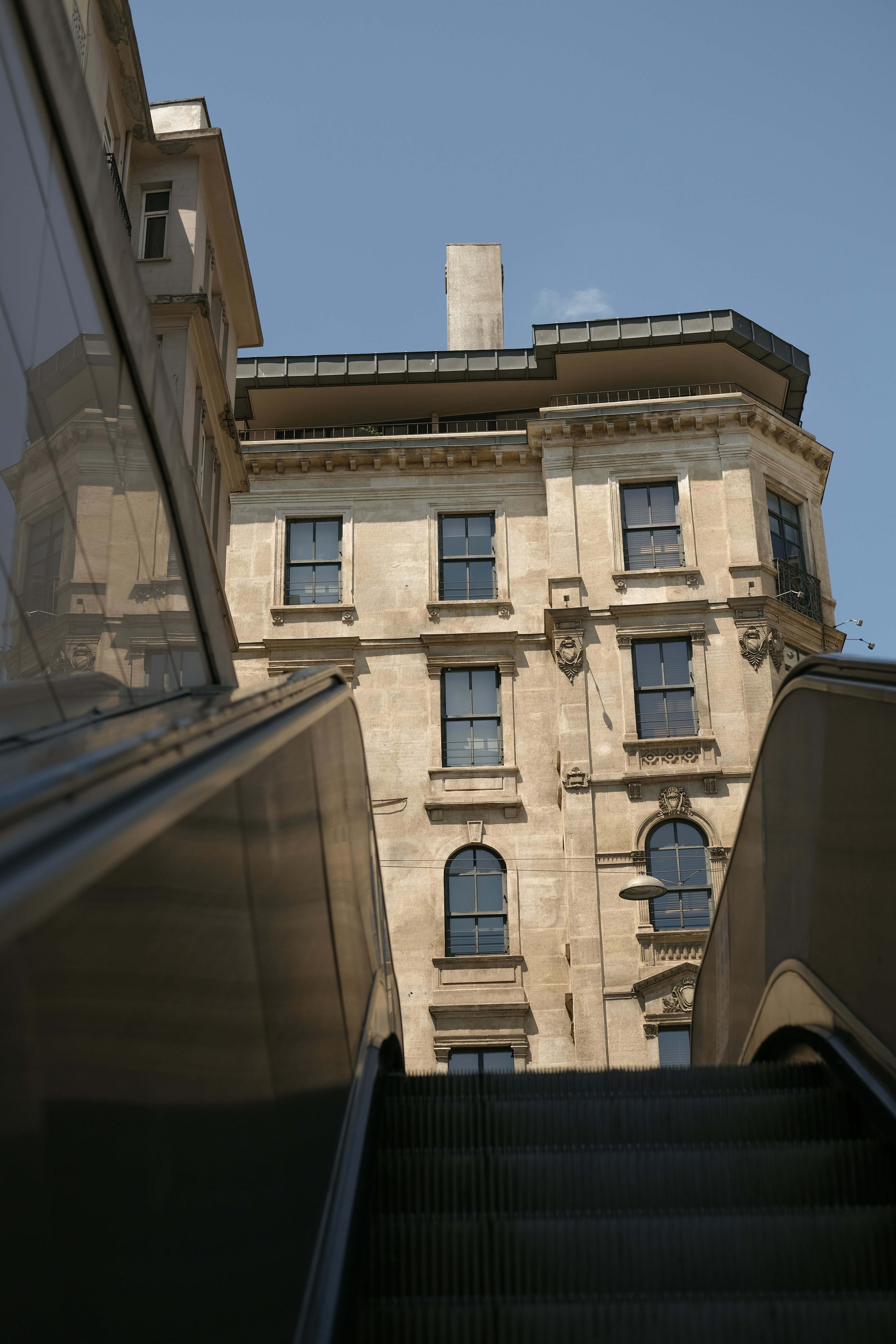 Ascending Facade: Sunlit limestone with Artful Window Details