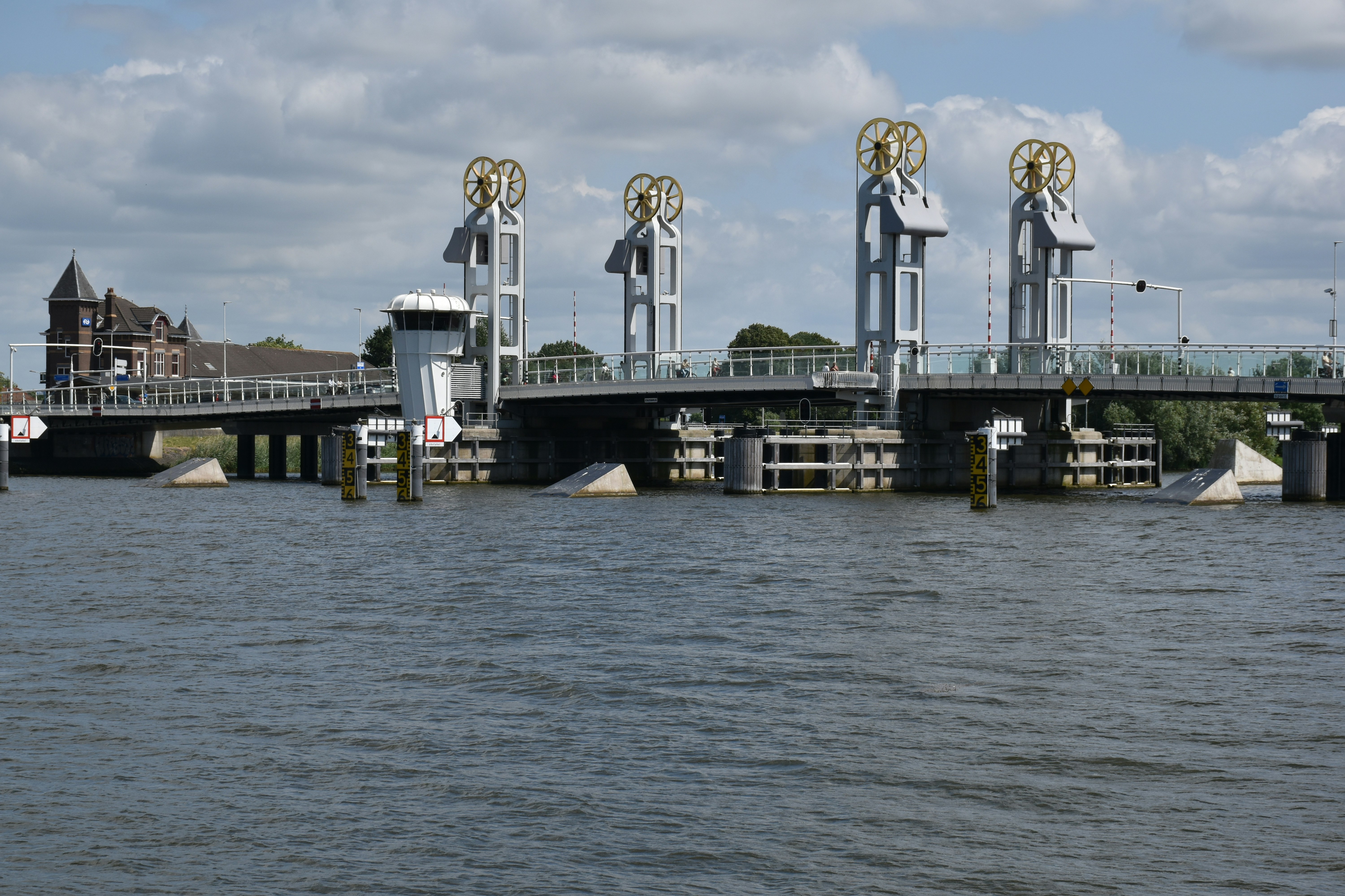 Industrial Crest: Wheel-Driven Towers Over a Calm River