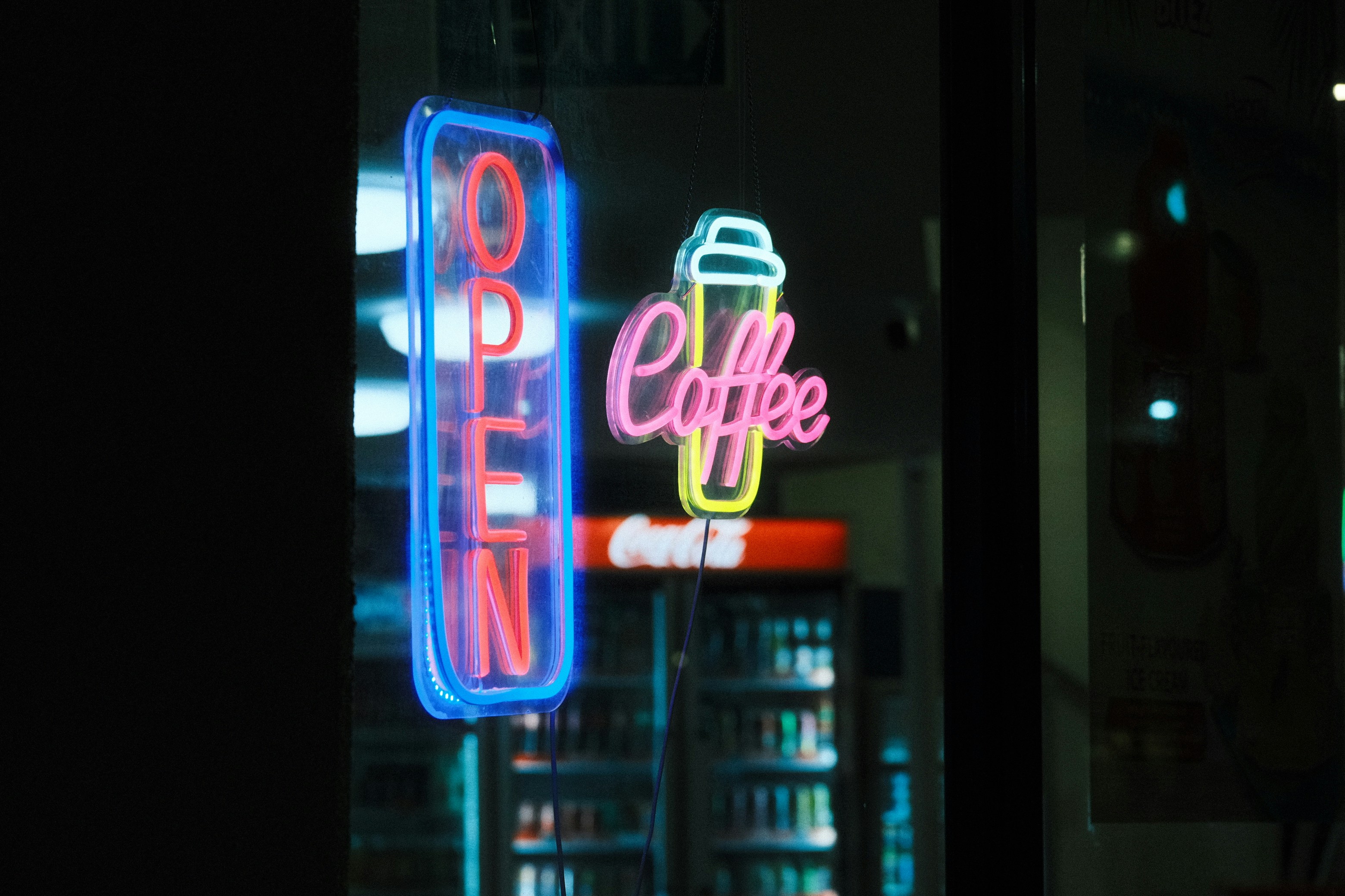 Neon Night Café: Open Sign and Coffee Glow Through Glass