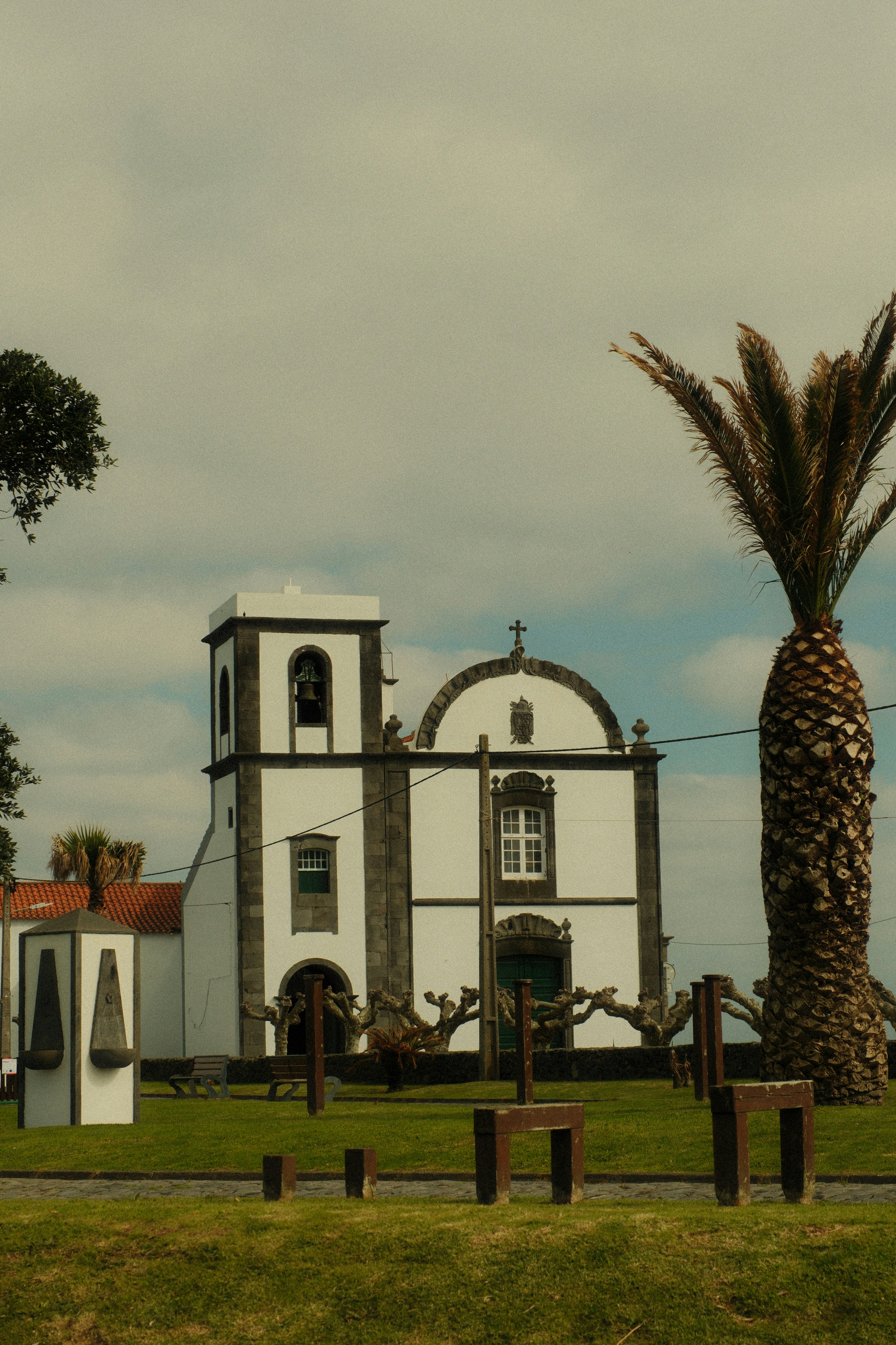 White-Church Garden Calm Under a Palm Arc