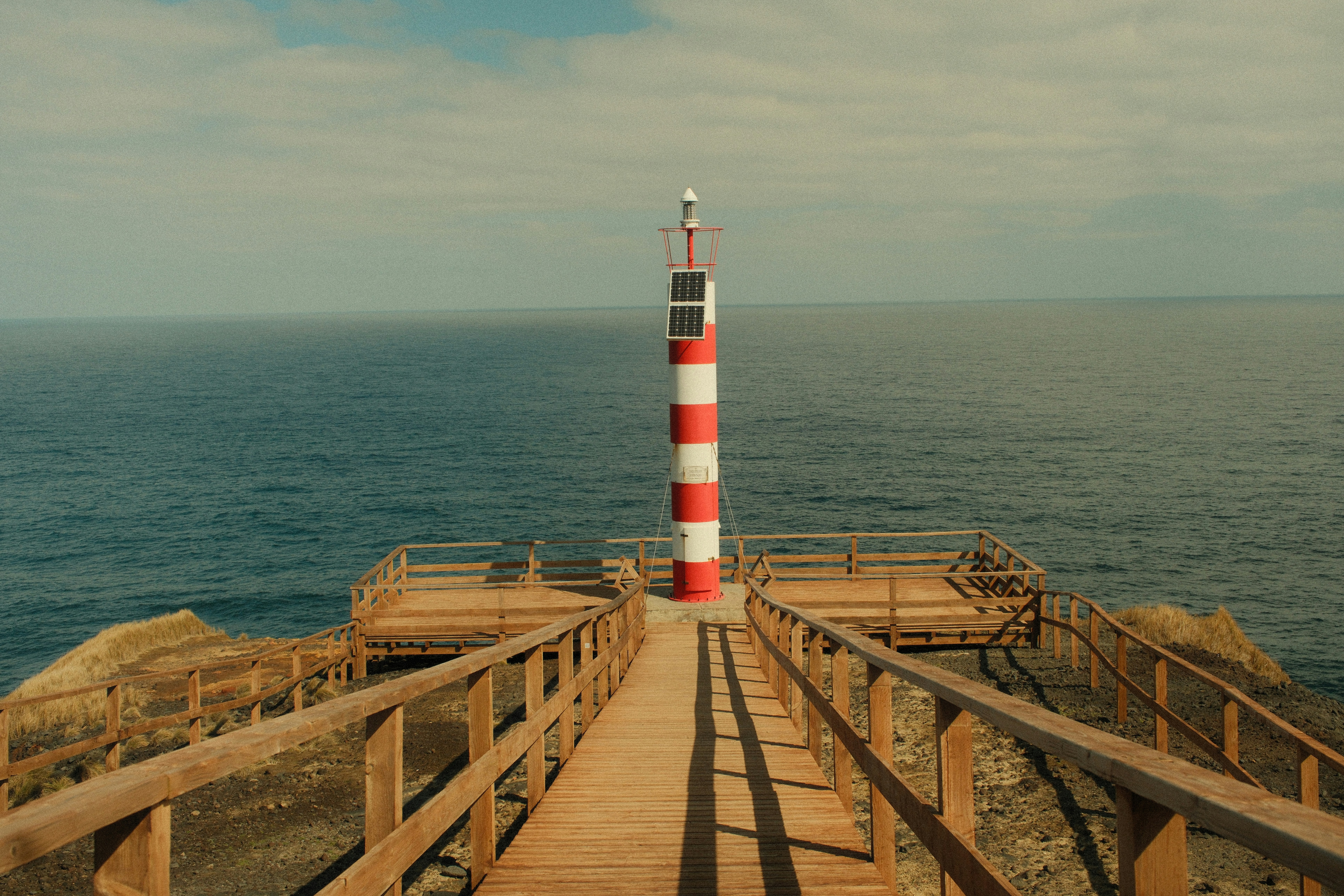 Lighthouse Path: A Red-and-White Beacon at the End of the Walkway