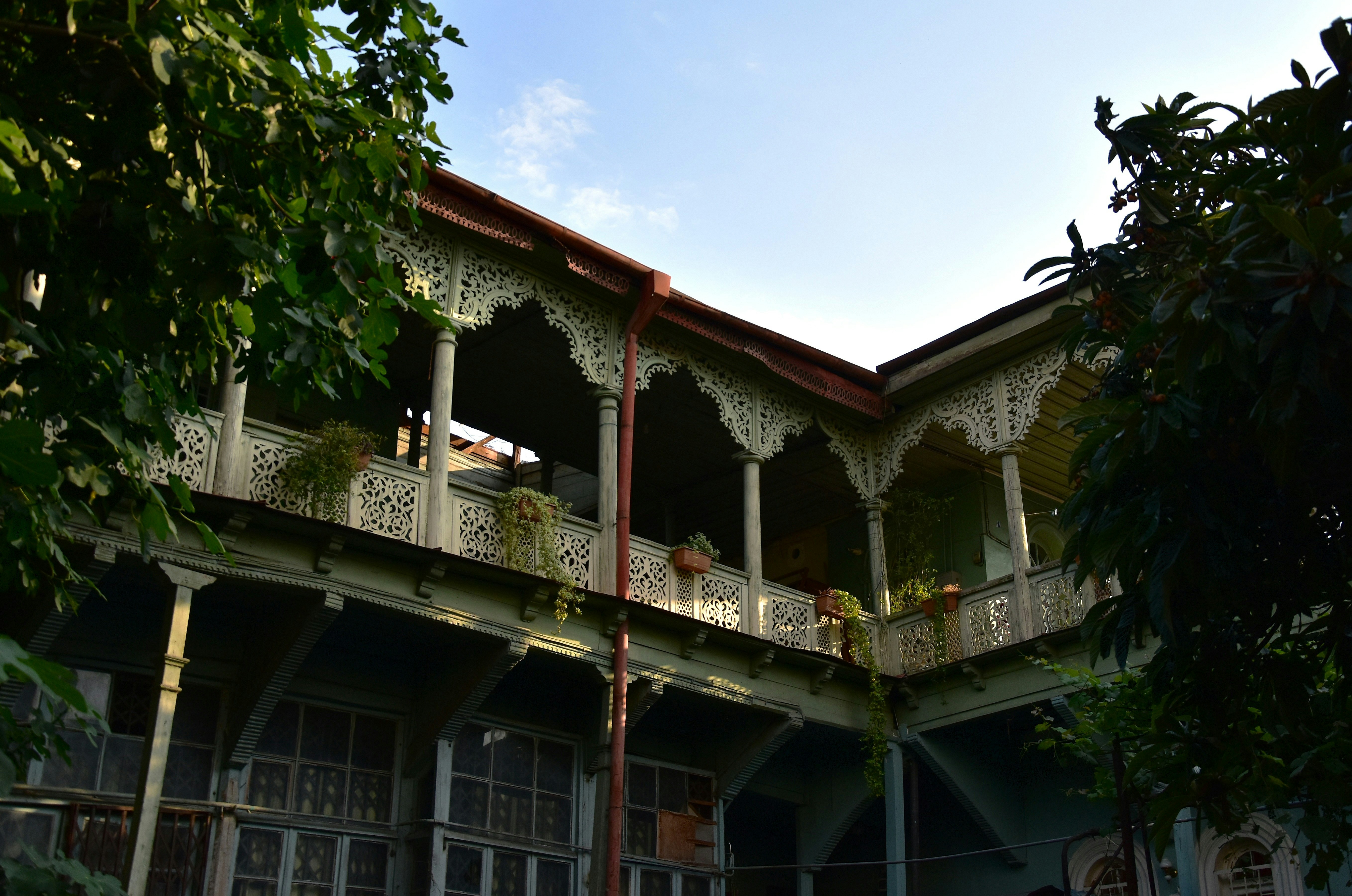 Ornate Balcony Overlook Above Shadowed Ground Floor