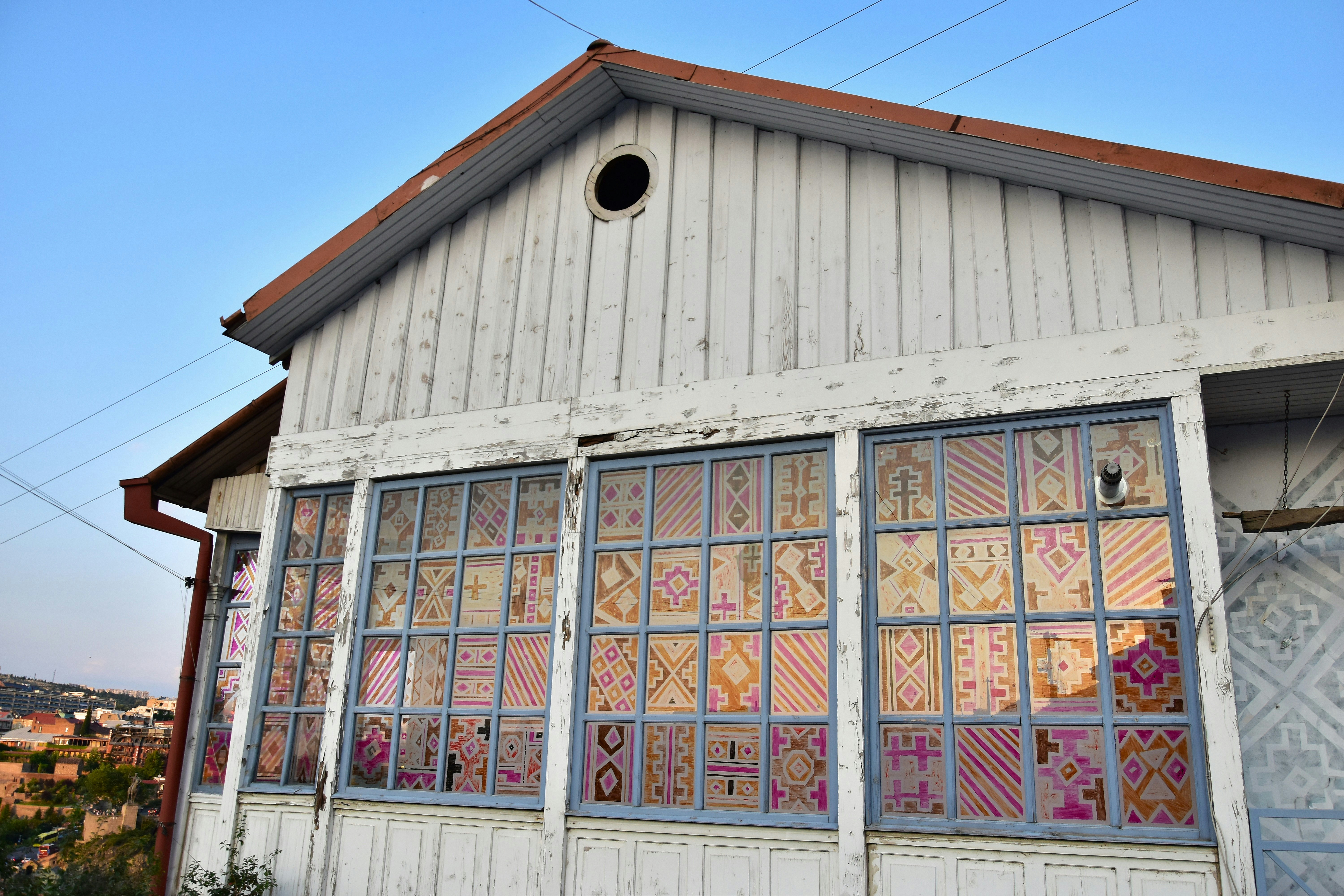 Colored Quilt Windows on a Weathered Village House