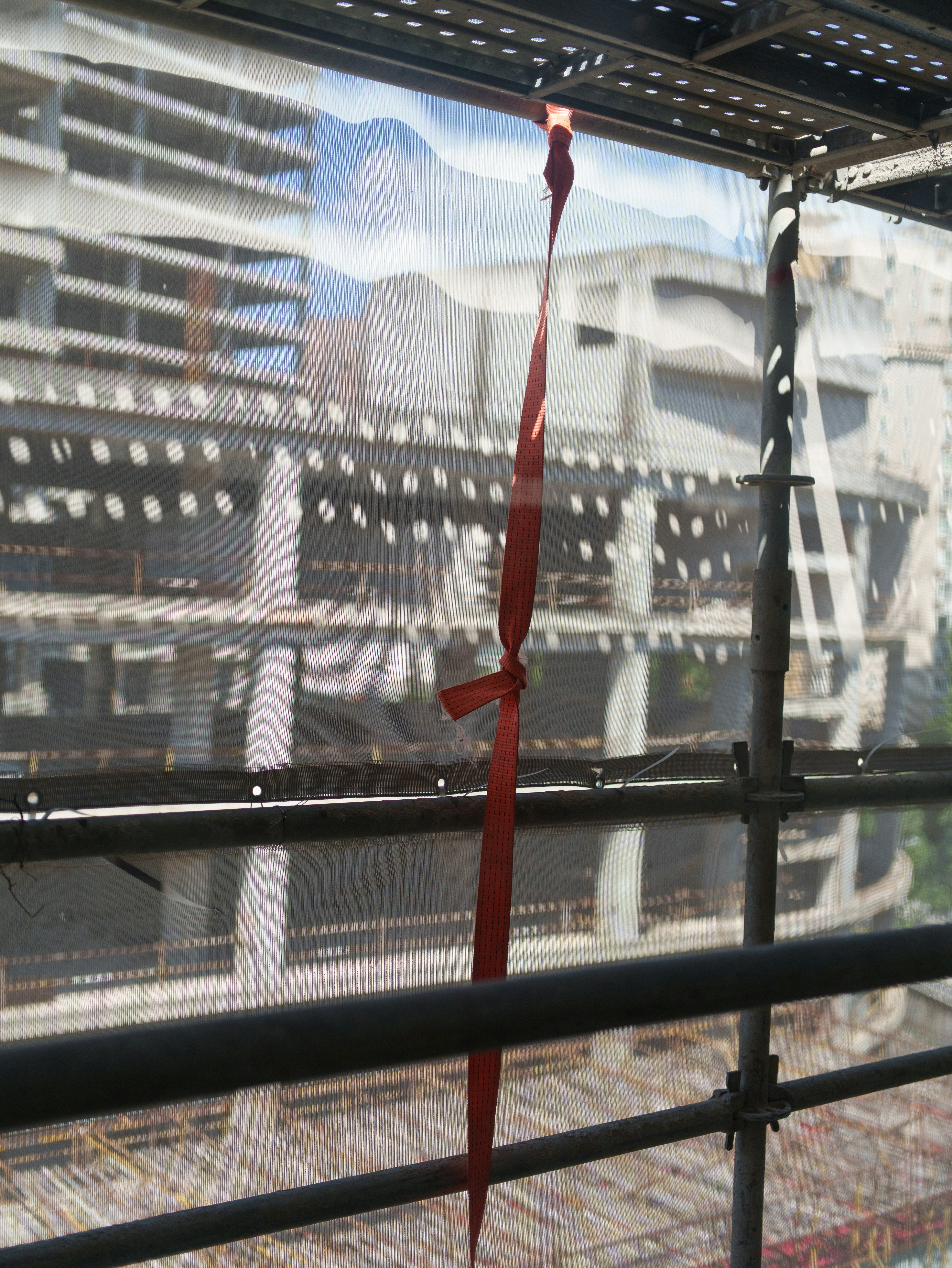 Red Ribbon in a Construction Frame: A Moment Under Steel and Sky