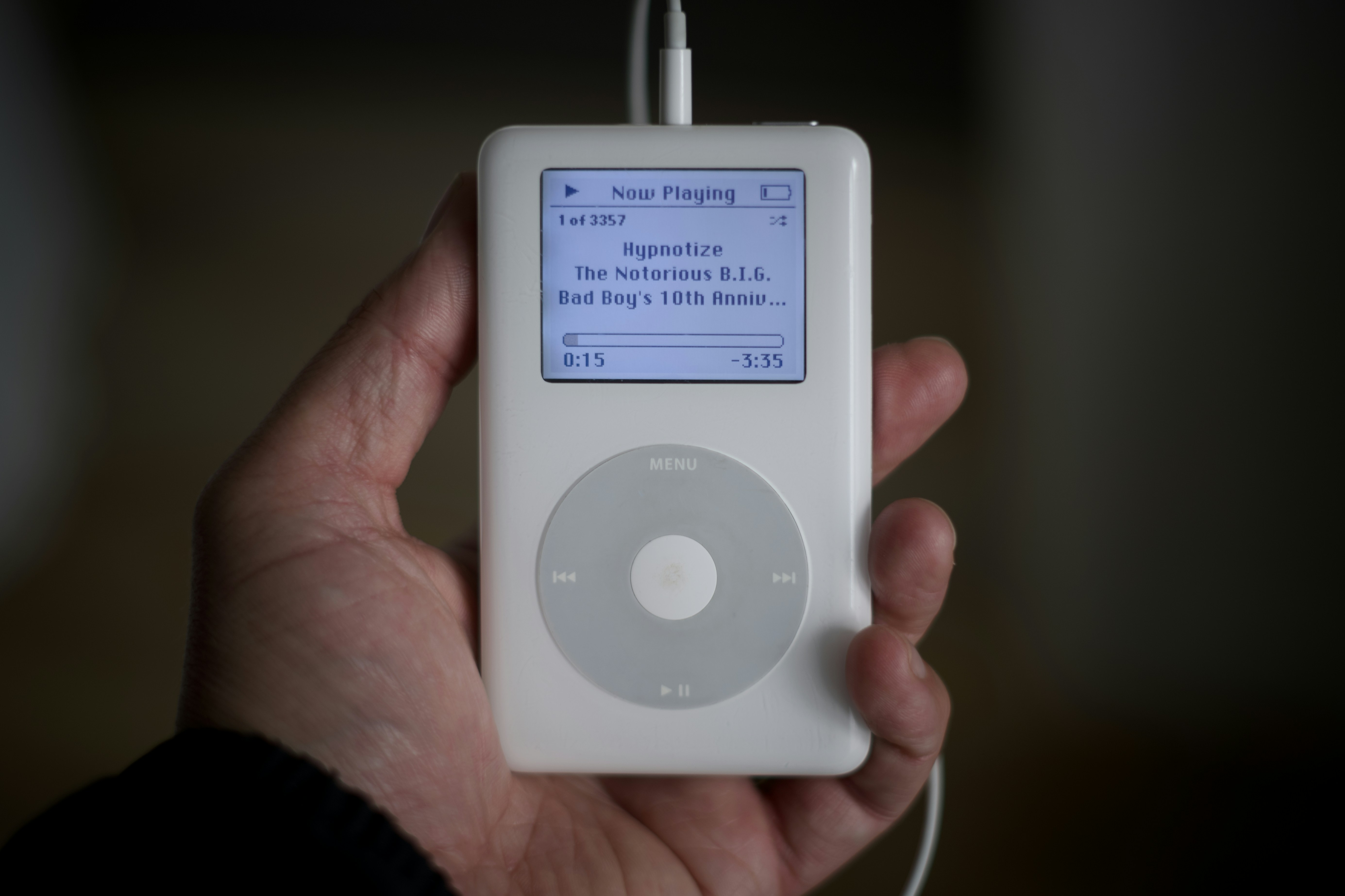 White iPod in a Hand: Minimalist Focus on a Retro Screen