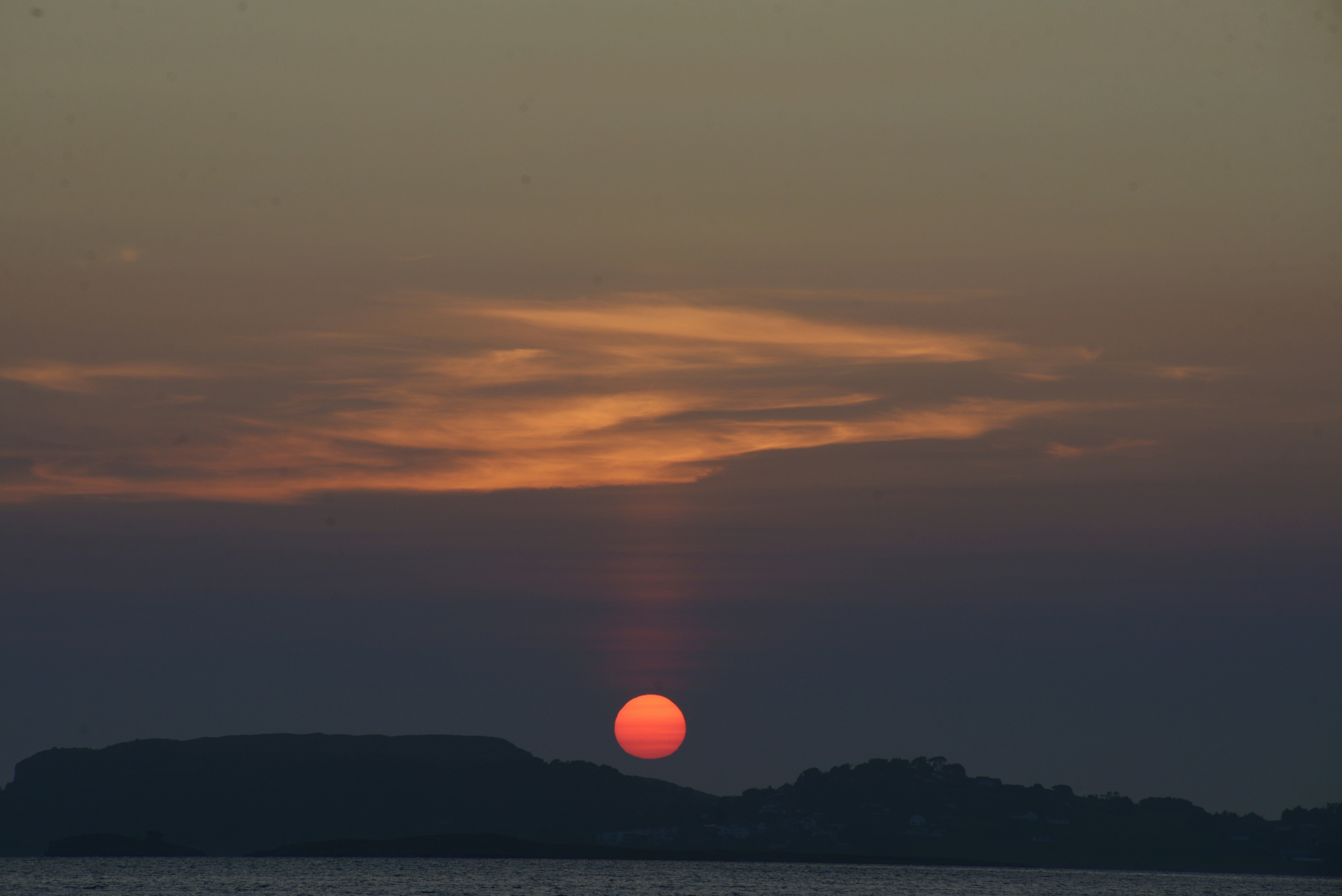 Sunset Sliver: The Red Orb Drops Below the Quiet Horizon