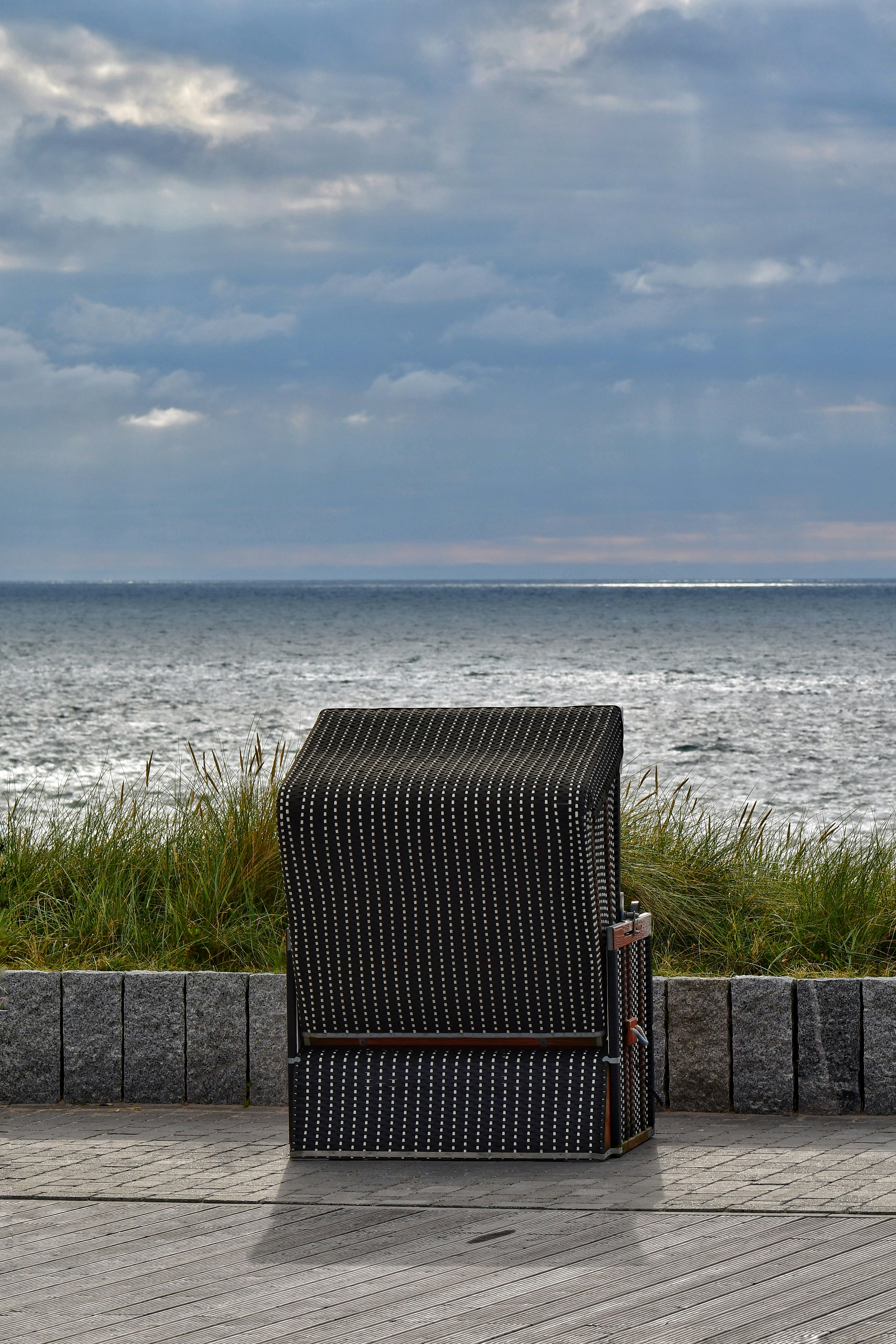 Midday Solitude: Rattan Chair at the Shoreline