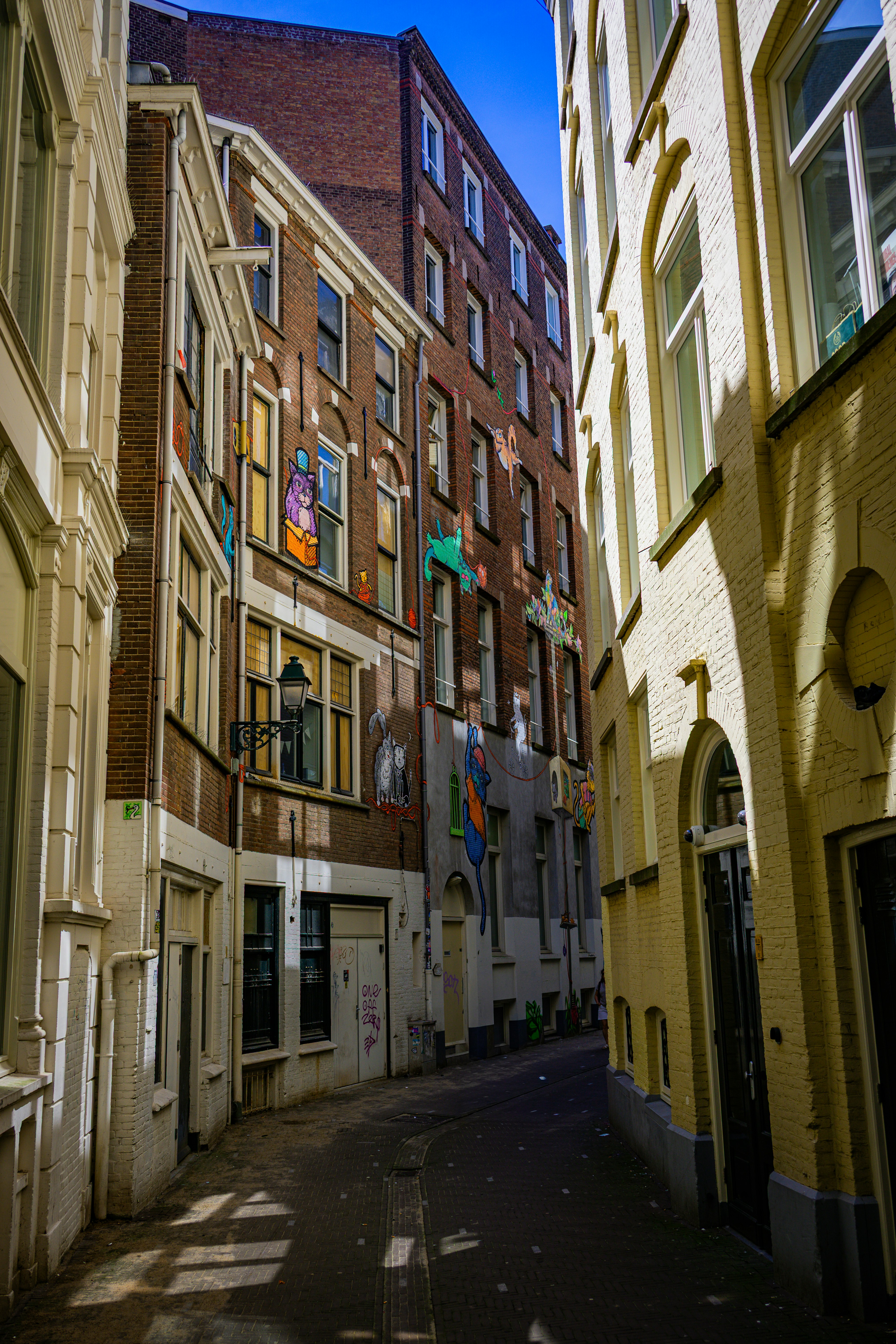 Sunlit Alleyway: Colorful Murals and Historic Facades Drawn Into Narrow City Path