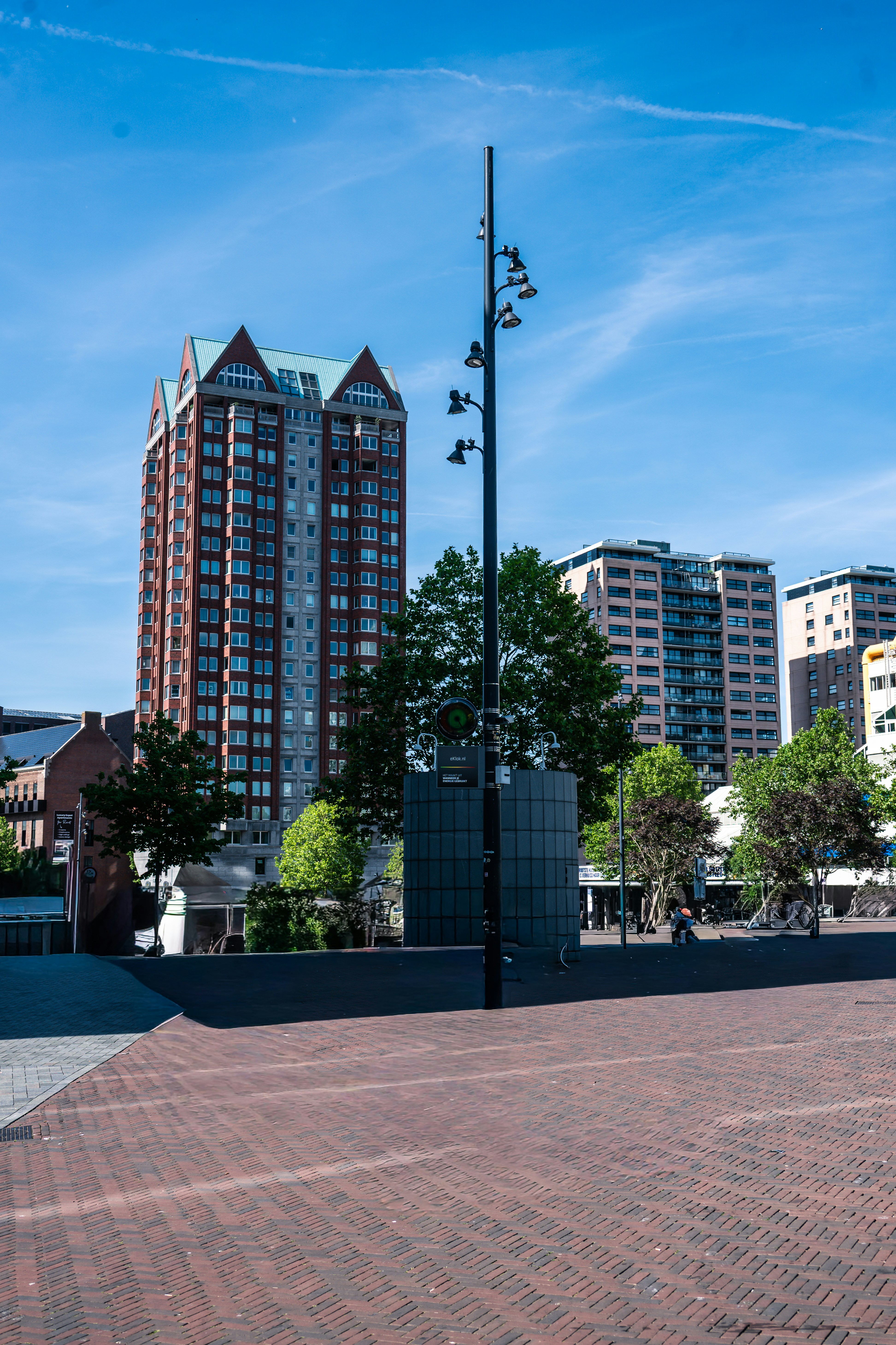 Cityscape Symphony: Tall red-brick tower rising over brick-paved plaza