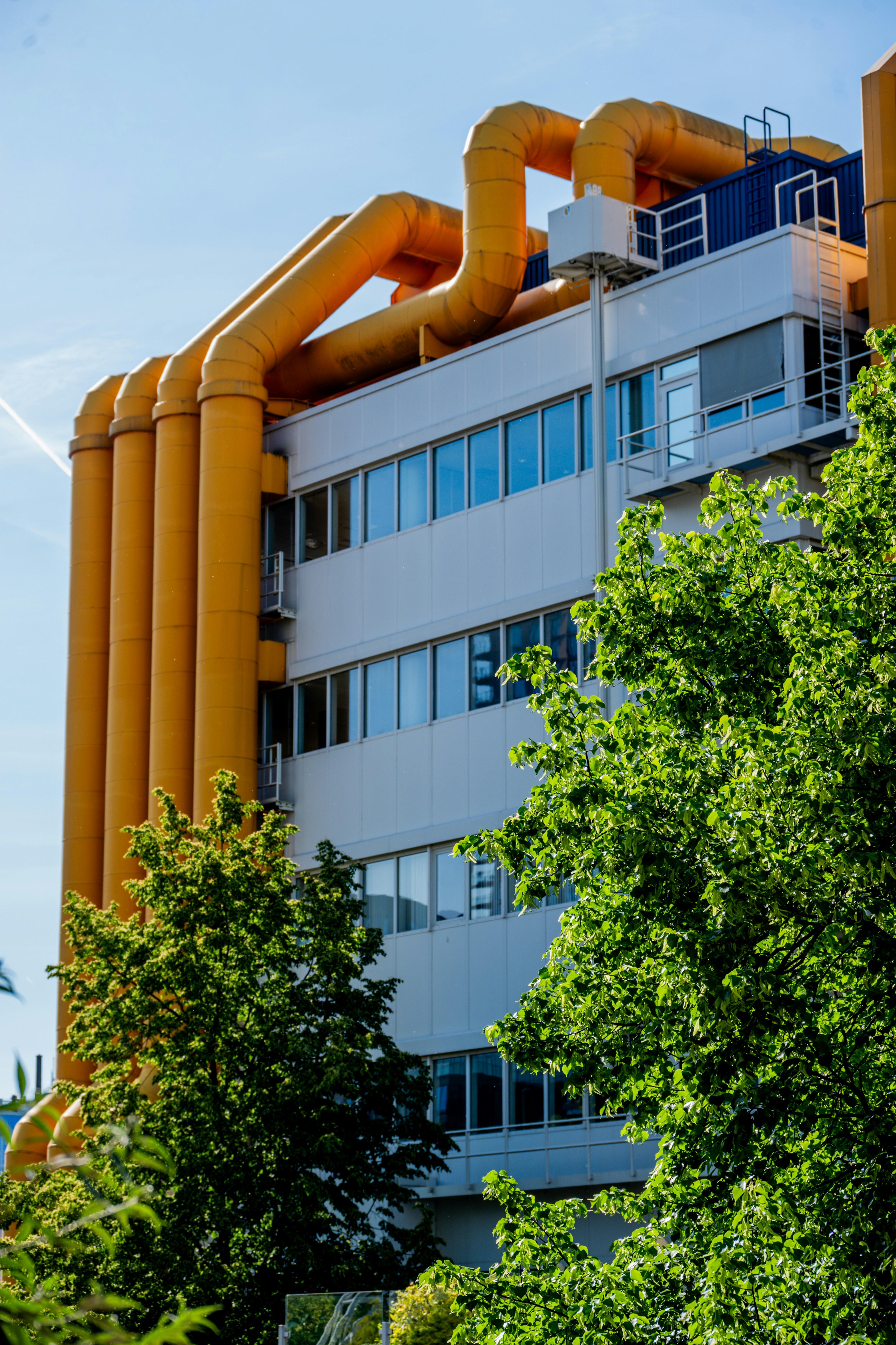 Yellow Industrial Vents Piercing a Modern Facade