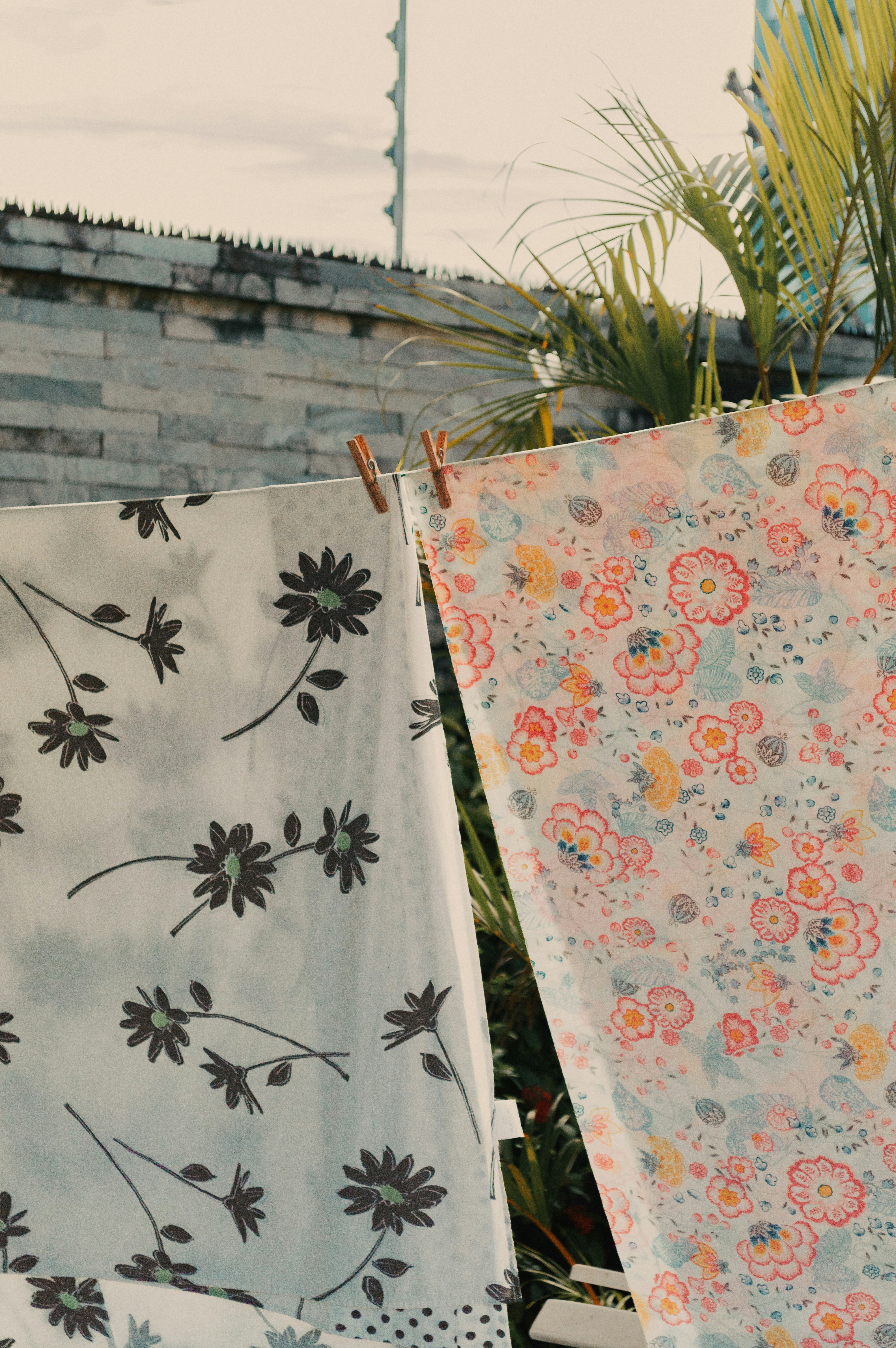 Clothesline Portrait: Floral Fabrics Against Sunlit Wall