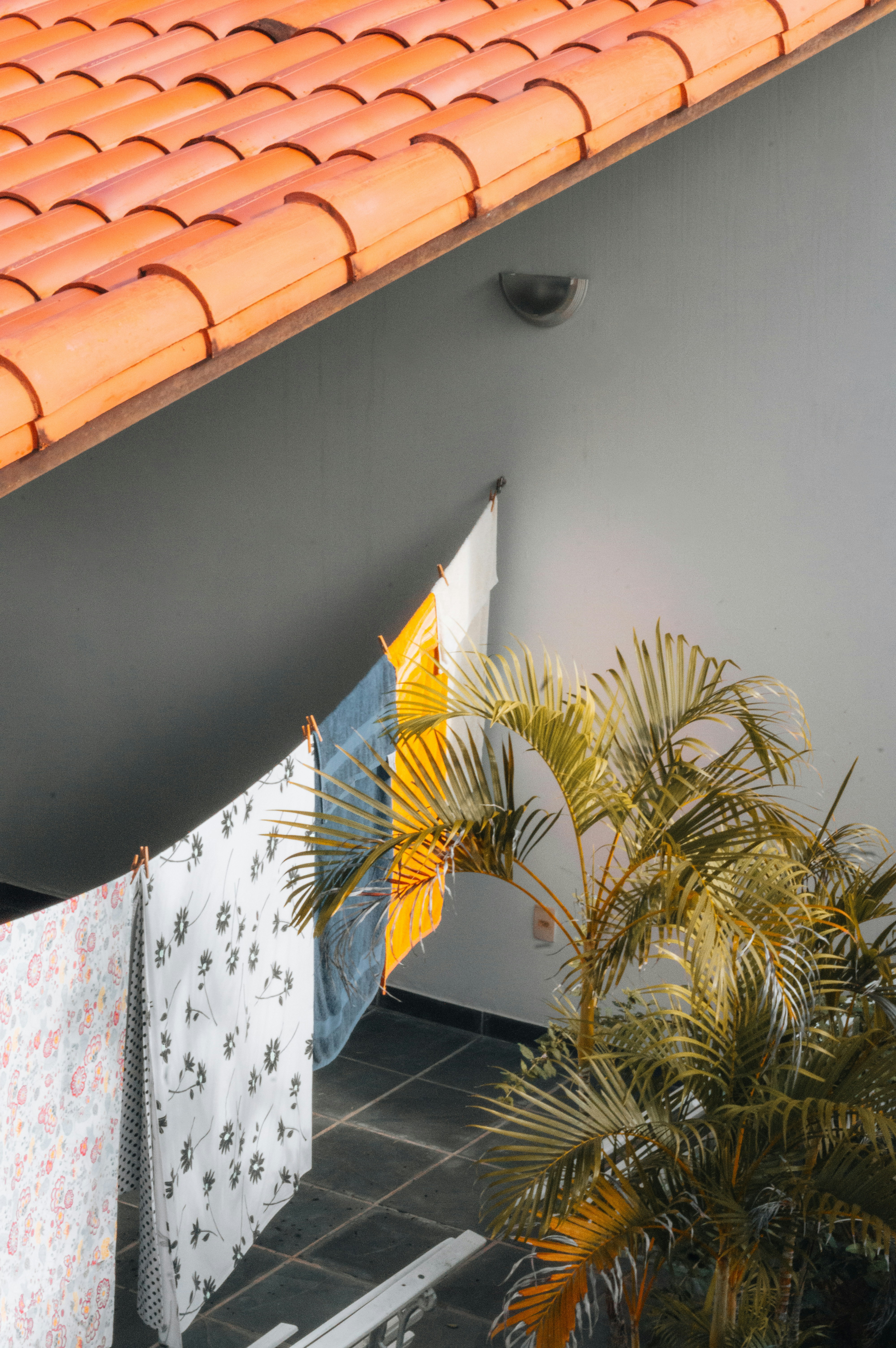 Clothes drying on a line under an orange tiled roof