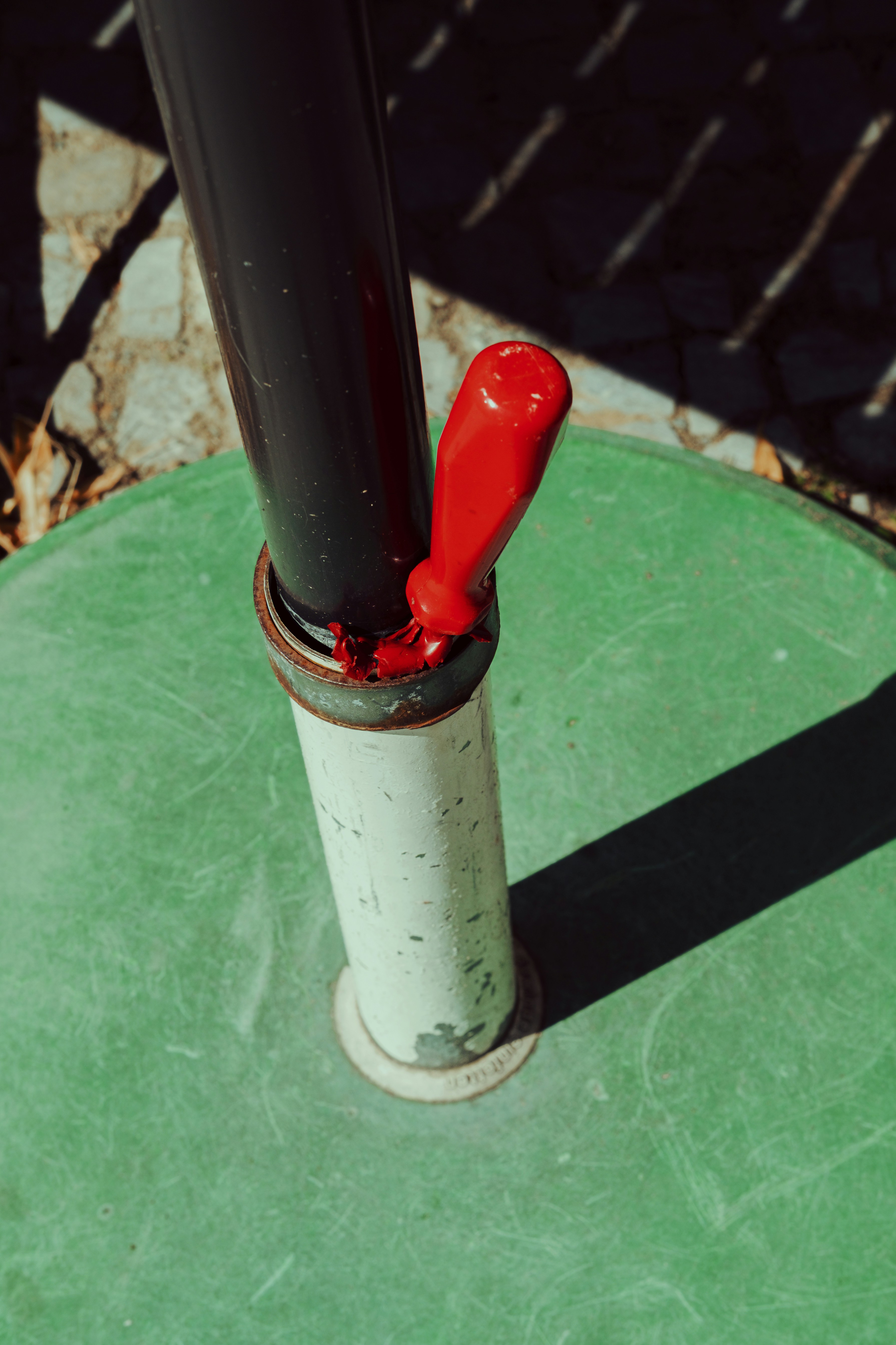 Red Lever Anchored in a Weathered Playground Post