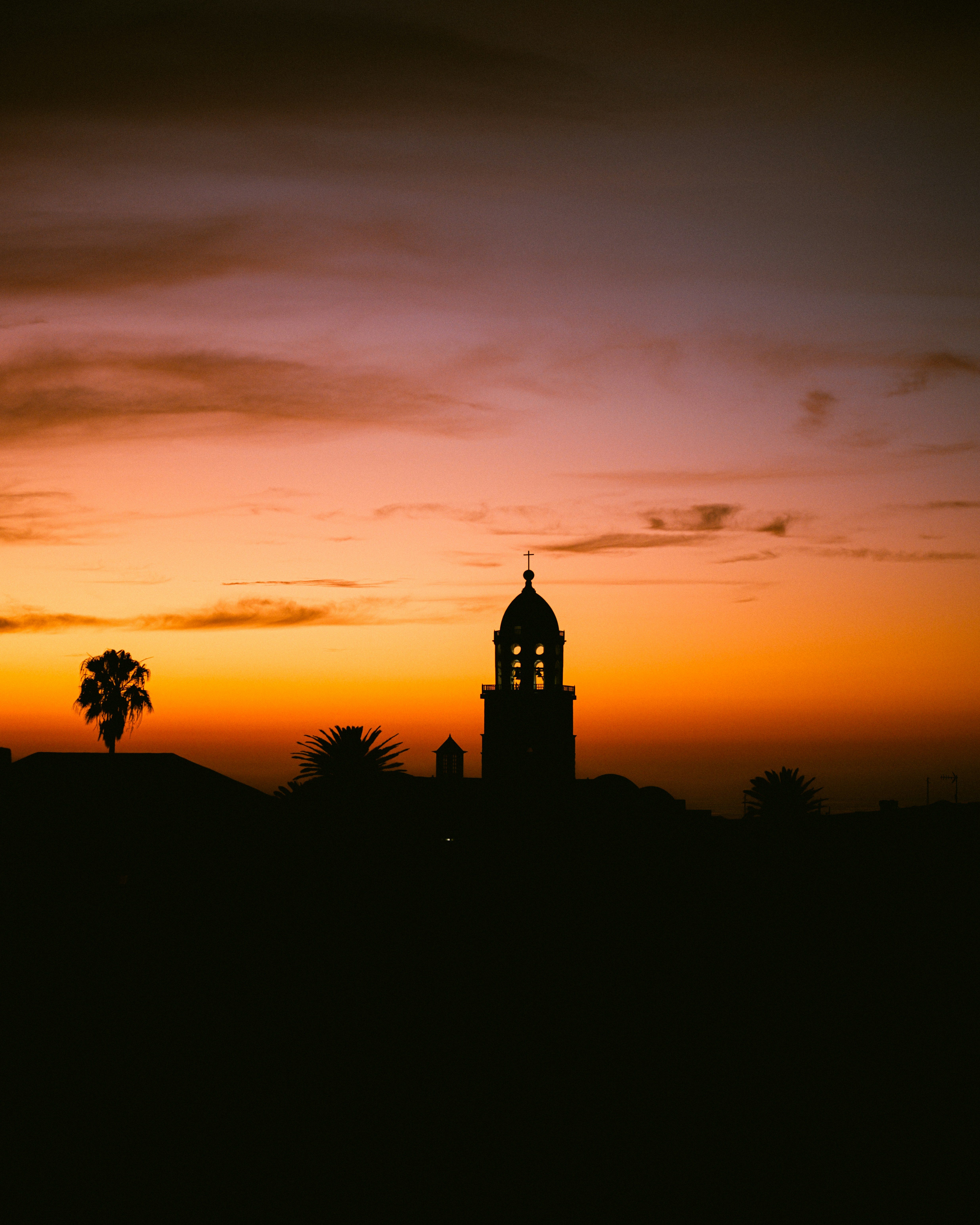 Silhouette at Sunset: A Coastal Clock Tower Against a Starlit Sky