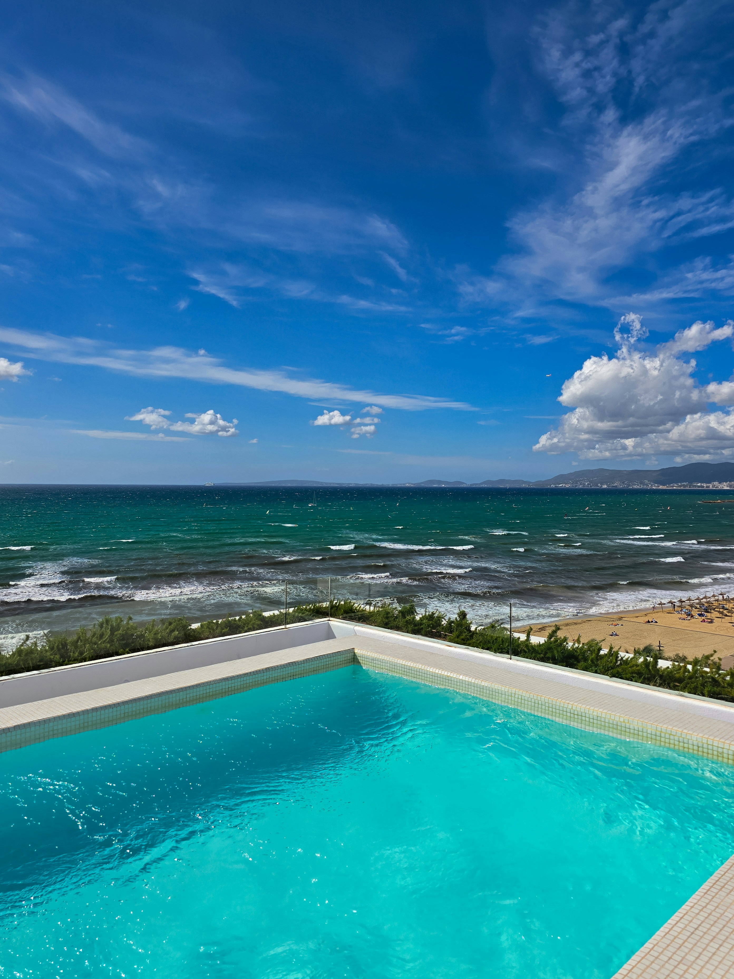 Turquoise Terrace: A Sunlit Ocean View from the Pool Edge
